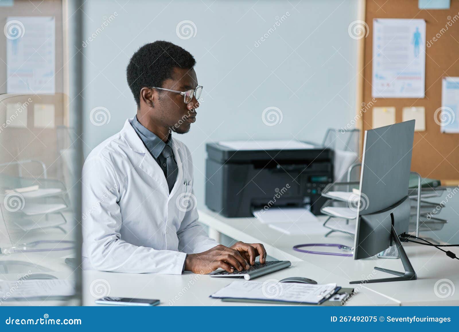Young Black Doctor Using Computer at Desk in Office Working in Clinic ...