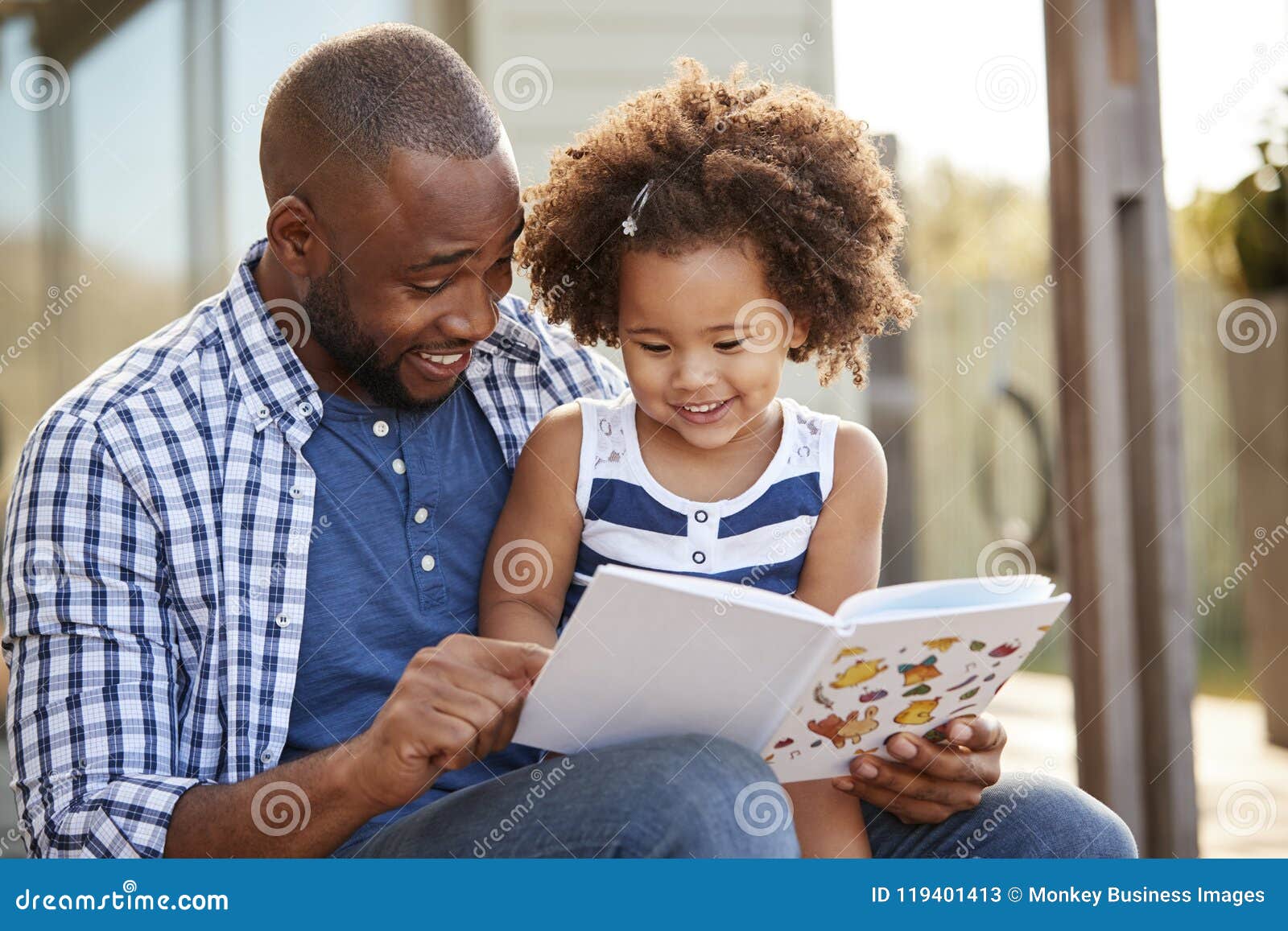 Young Black Father and Daughter Reading Book Outside Stock Image ...