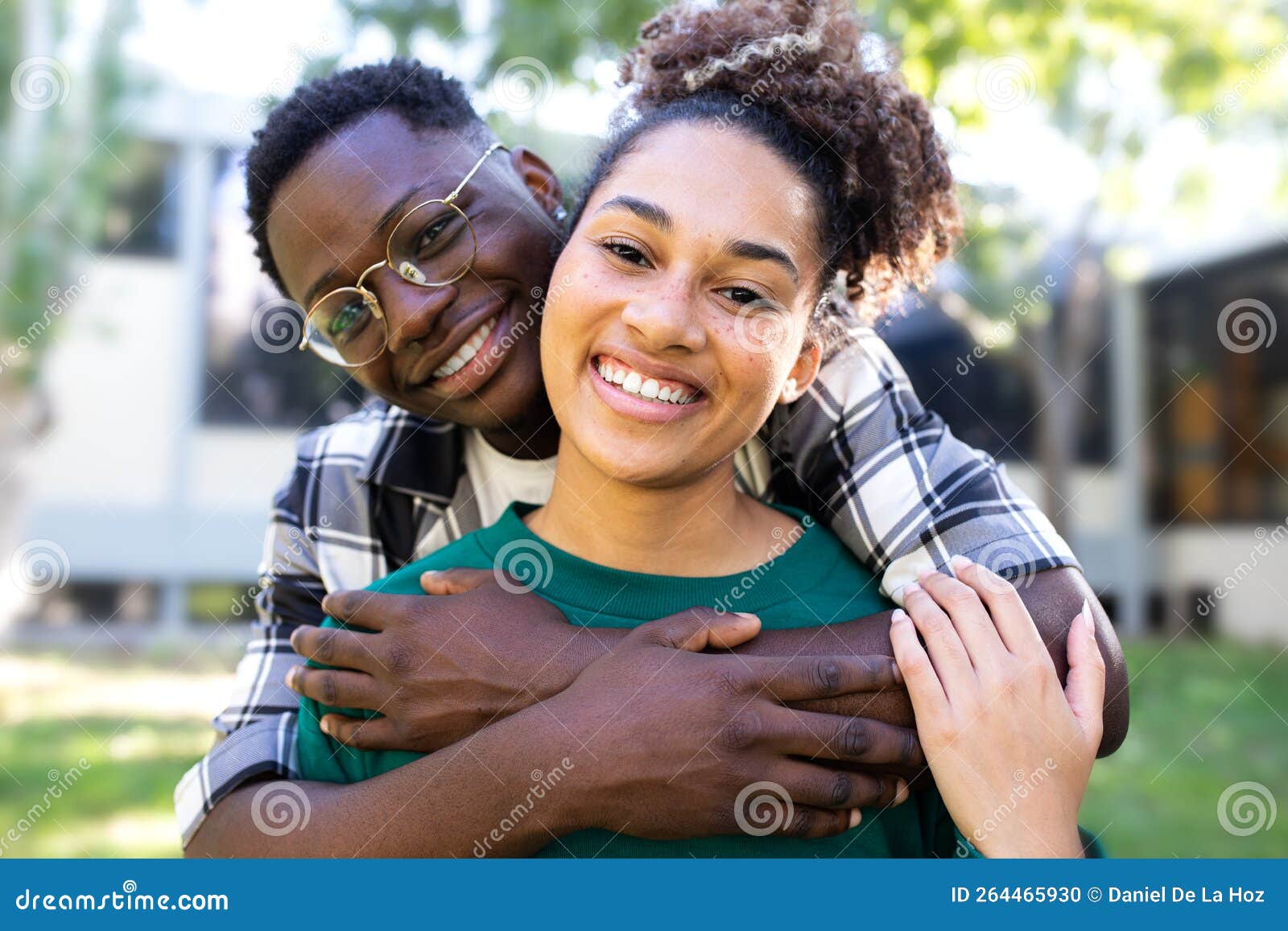 Young Black Loving Couple Embracing Outdoors Looking At Camera Loving