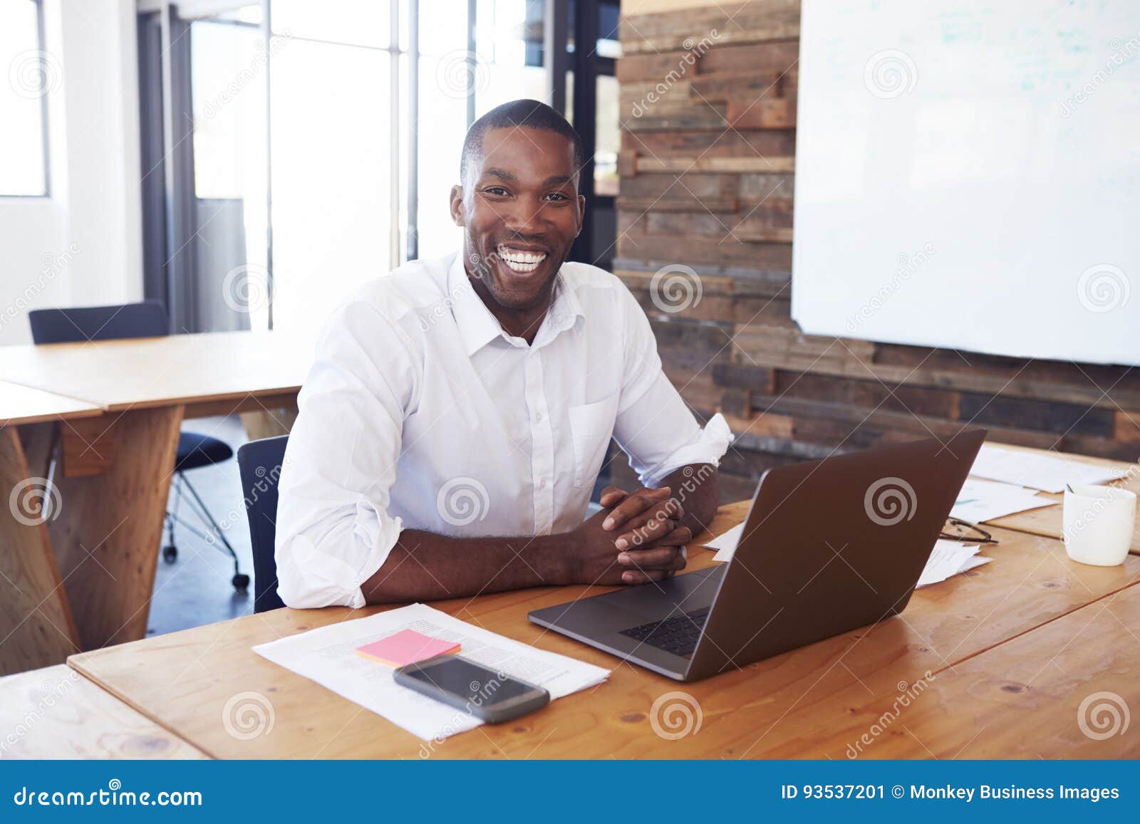 Young Black Man at Desk with Laptop Computer Looks To Camera Stock ...