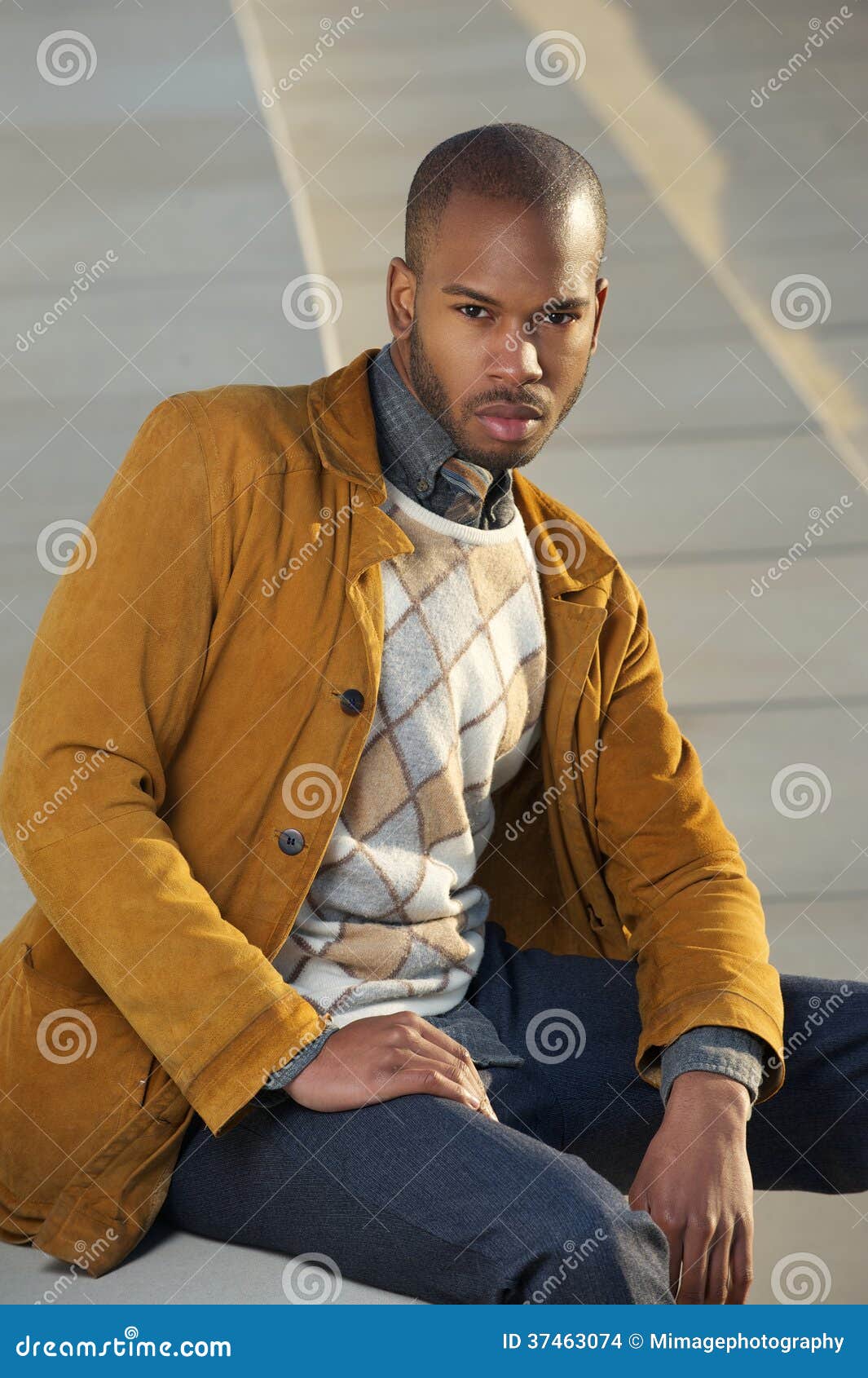 Young Black Man Sitting Outdoors with Serious Expression Stock Photo ...