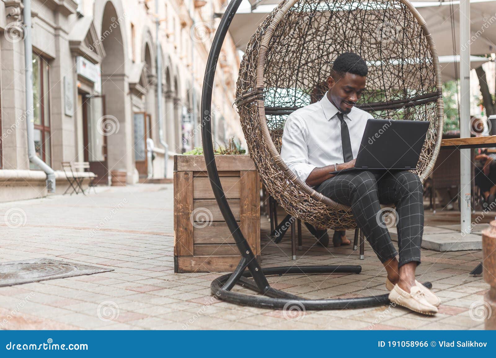 Young Black Man Using a Laptop Computer Outside a Cafe Stock Photo ...