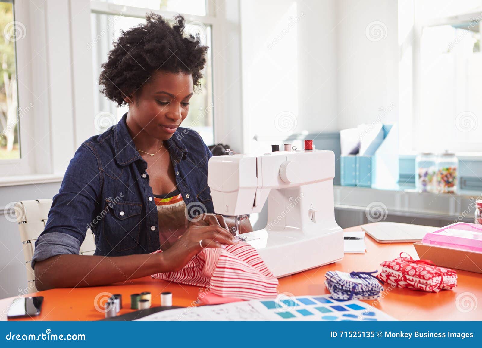 Young Black Woman Stitching Fabric Using A Sewing Machine Stock Image