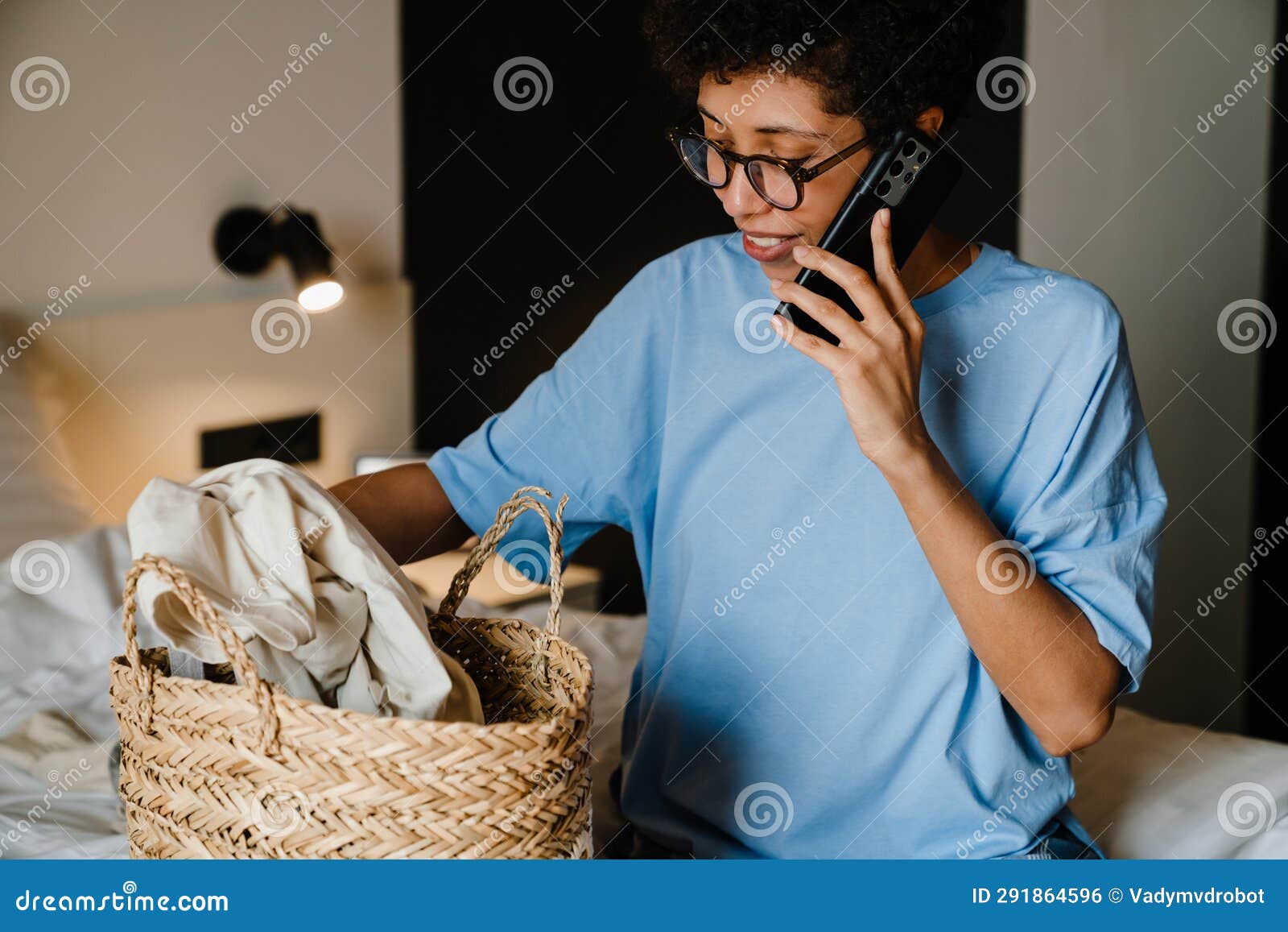 Young Black Woman Talking on Mobile Phone while Doing Housework Stock ...