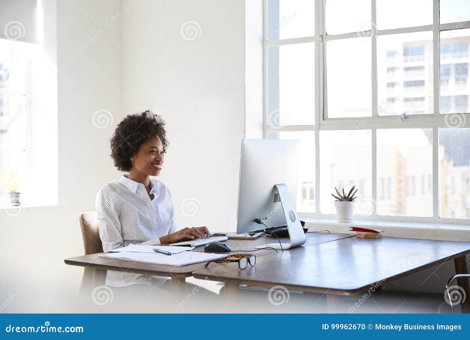 Young Black Woman Working at Computer in an Office Stock Photo - Image ...