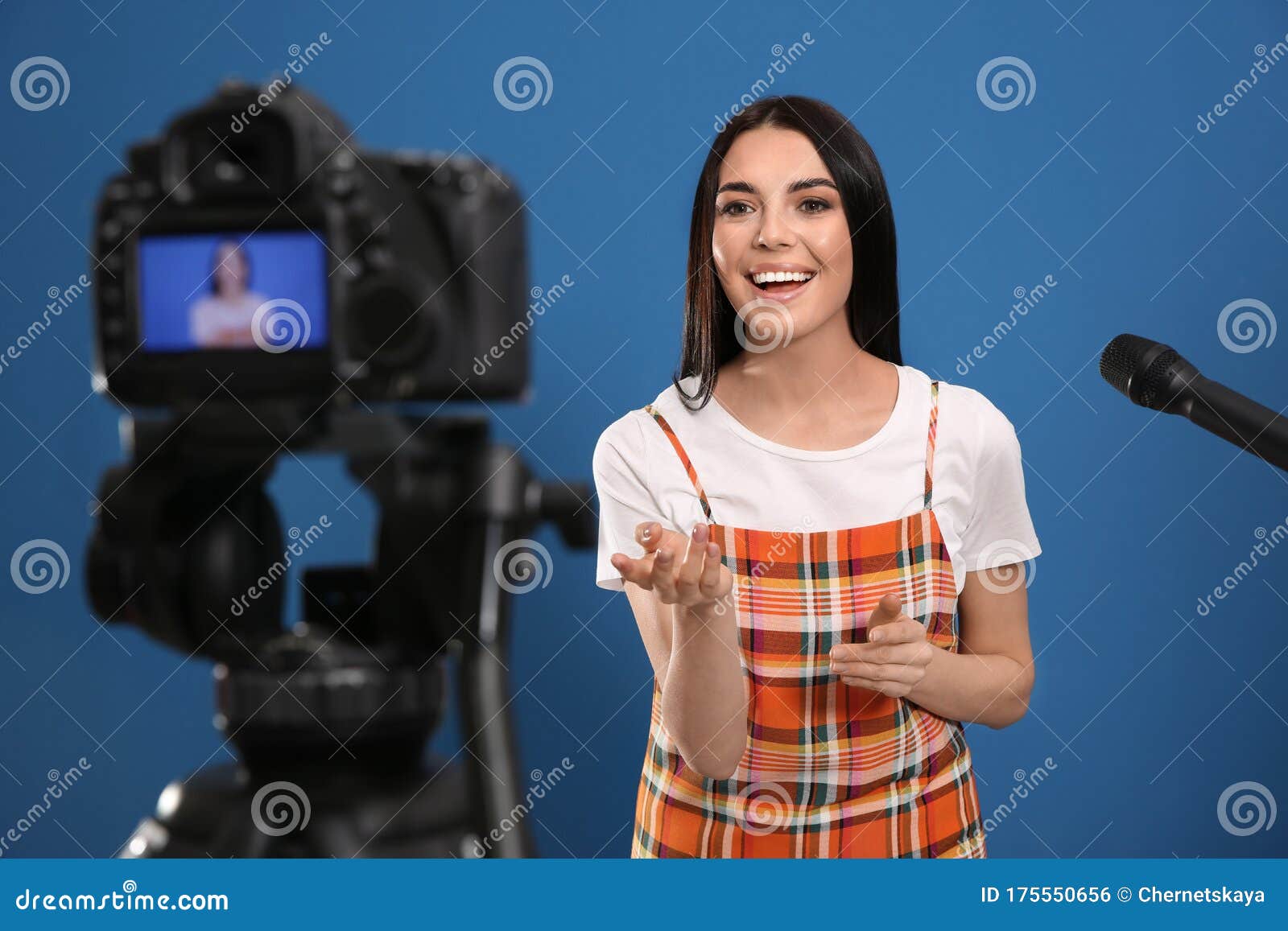 Young Blogger with Microphone Recording Video on Camera Against ...