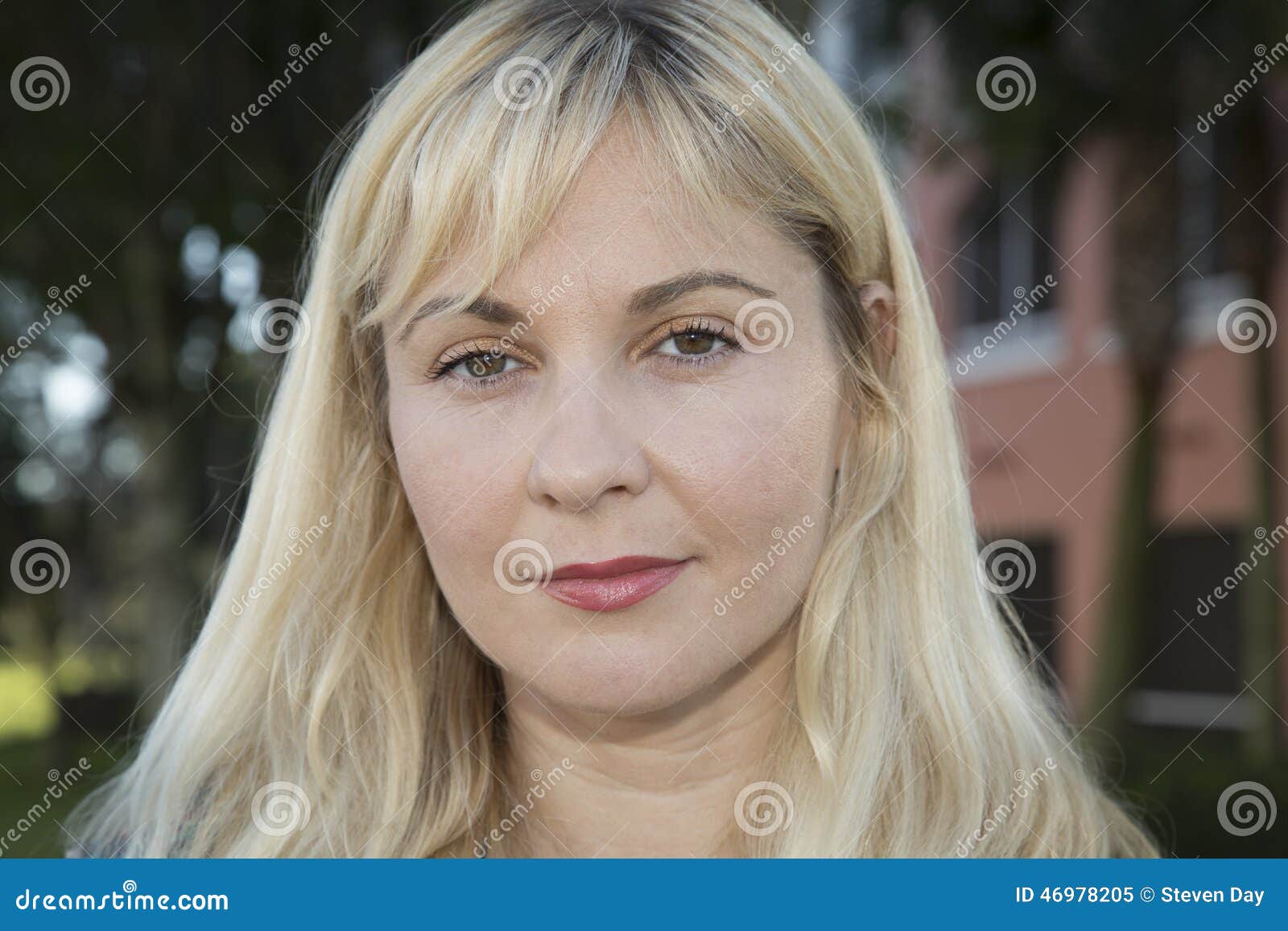 Young Blond Female Model Peering into Camera Straight Faced Stock Image ...