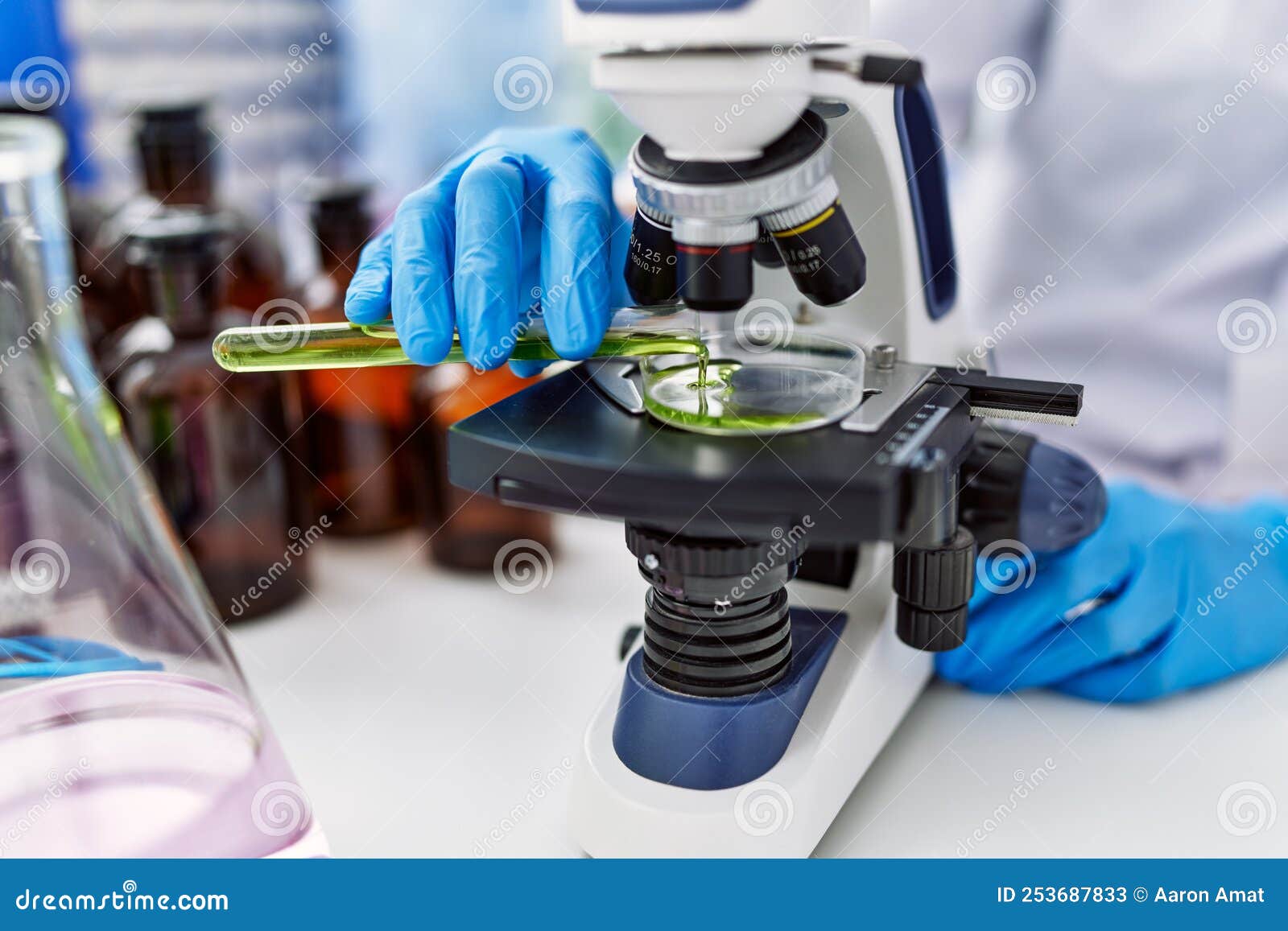 Young Blond Man Scientist Using Microscope Pouring Liquid on Sample at ...