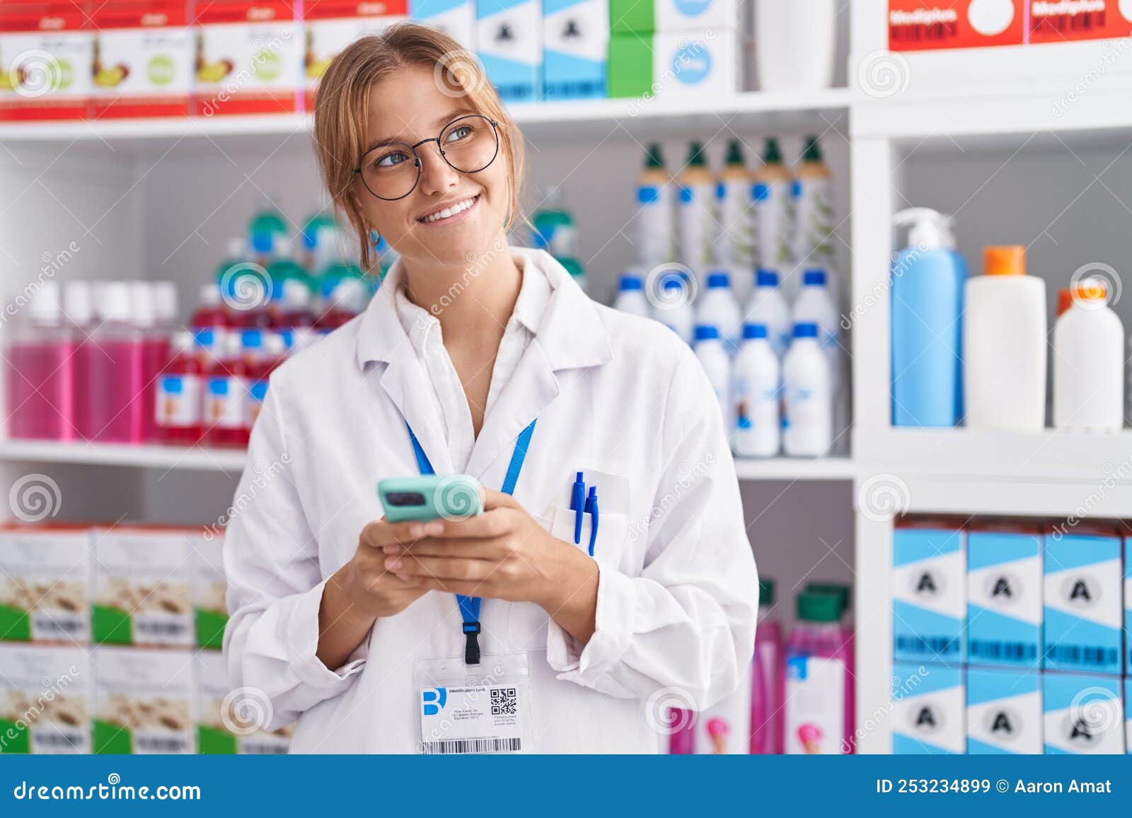Young Blonde Girl Pharmacist Using Smartphone Working at Pharmacy Stock ...