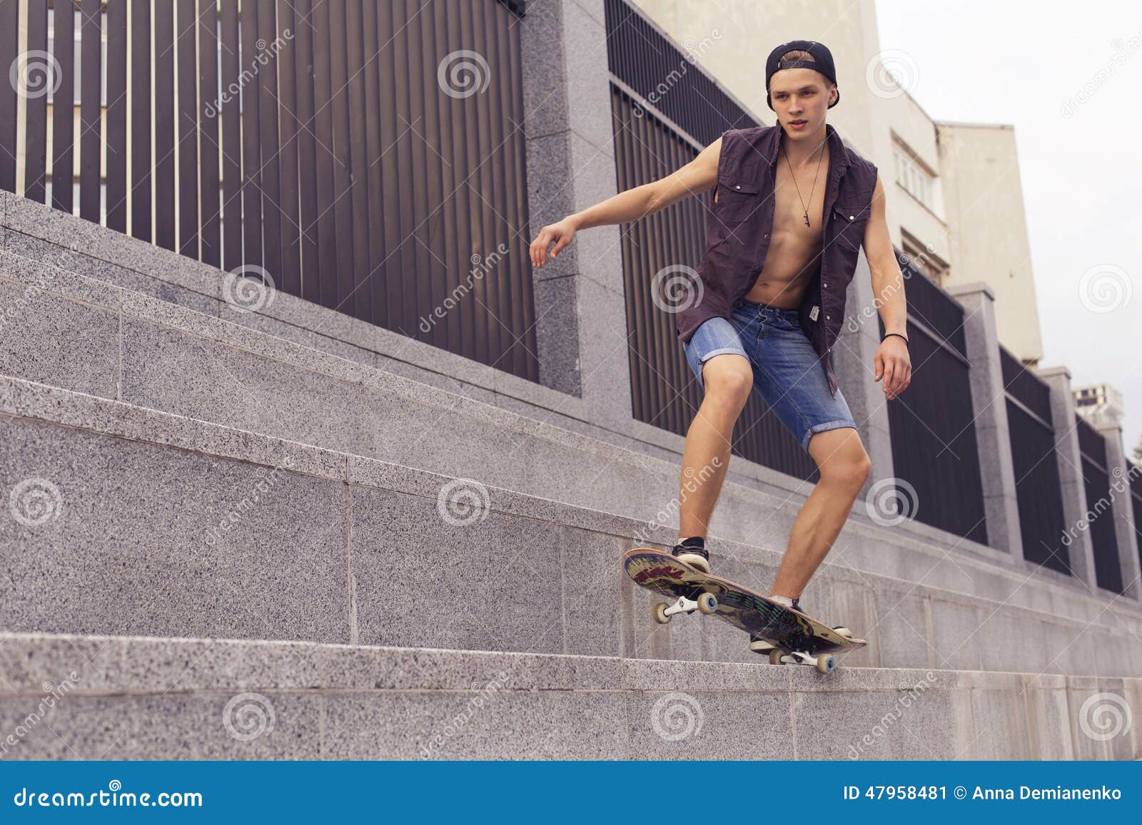 Young Blonde Guy On Skateboard In Casual Outfit In The Urban Cit Stock