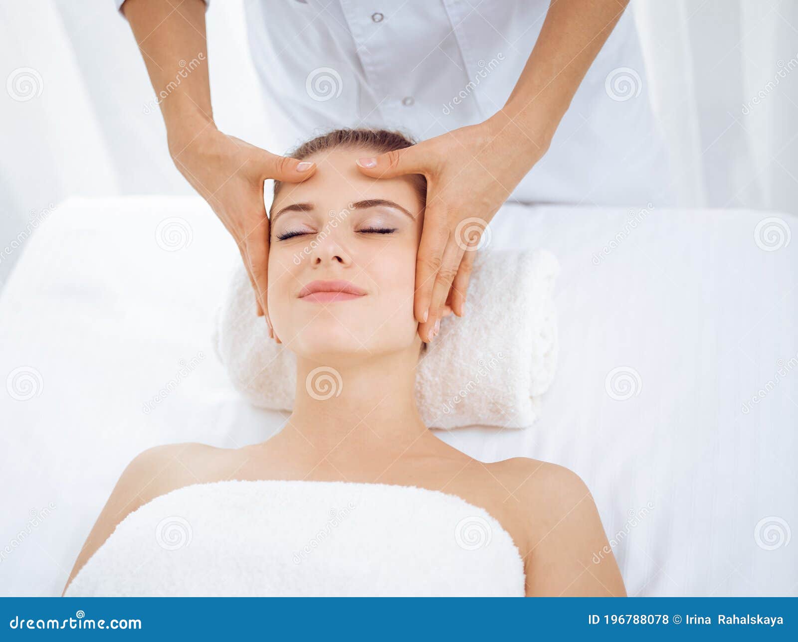 Young And Blonde Woman Enjoying Facial Massage In Spa Salon Beauty