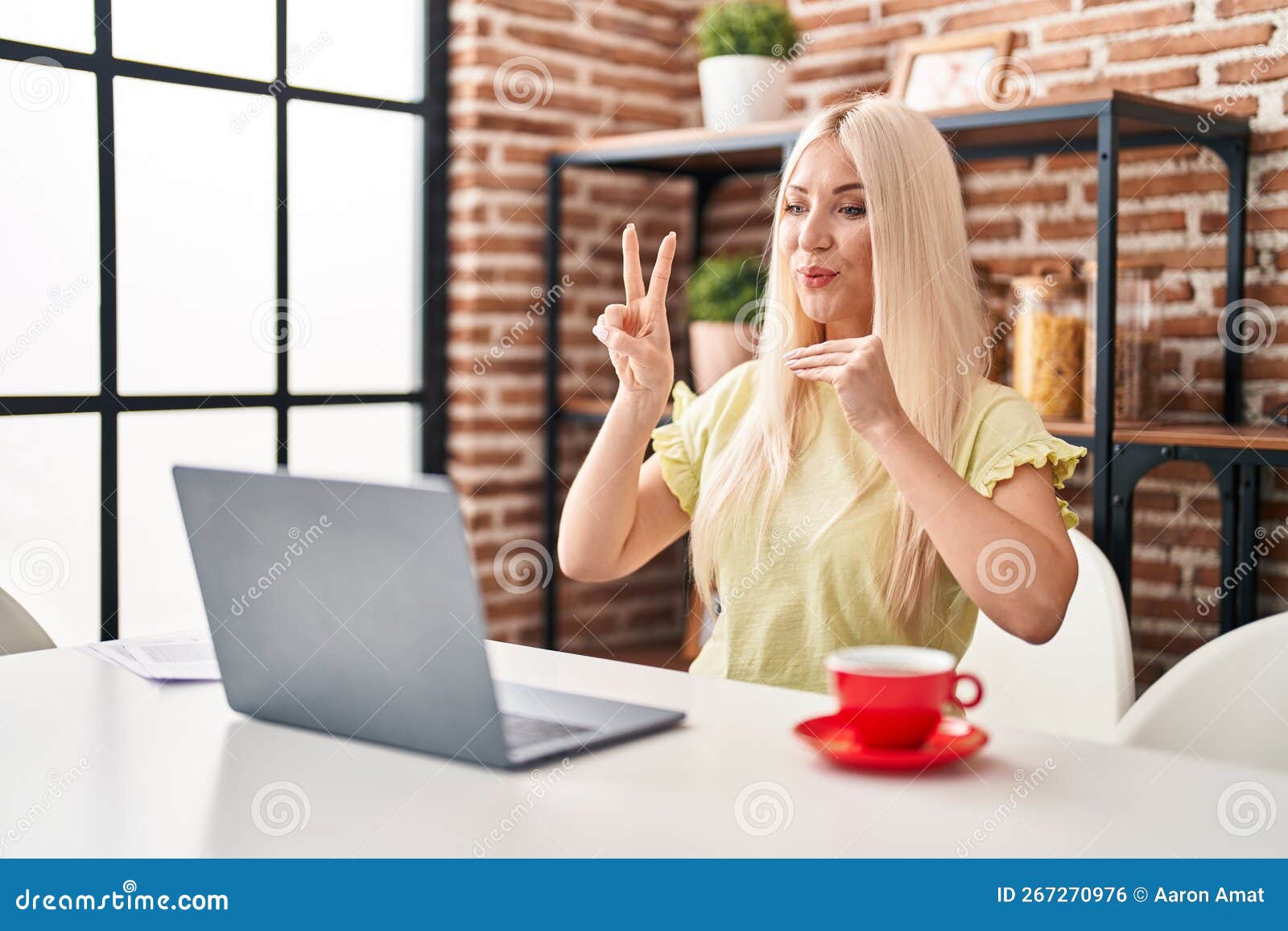 Young Blonde Woman Having Video Call Using Deaf Language at Home Stock ...