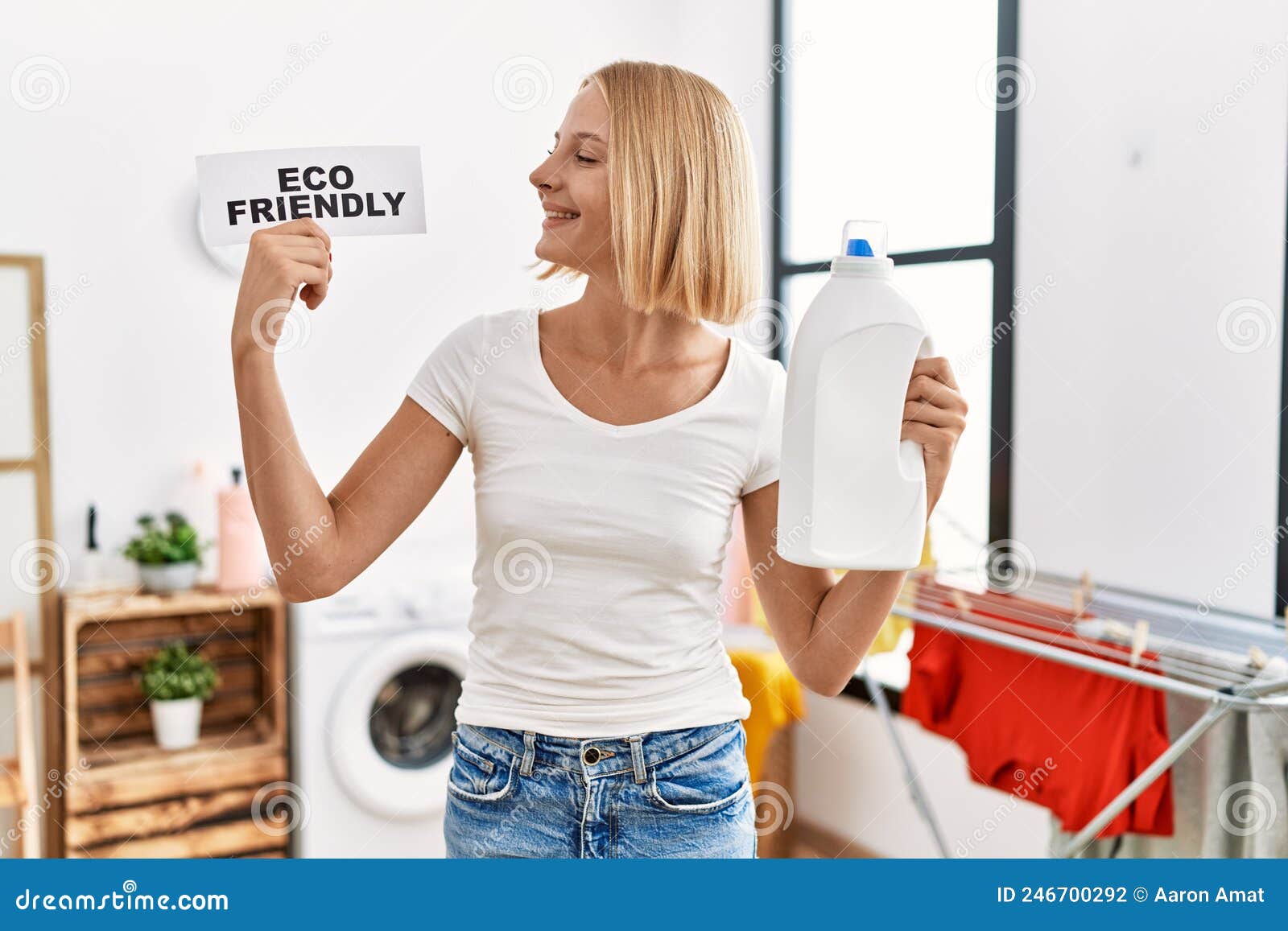 Young Blonde Woman Holding Detergent Bottle And Eco Friendly Banner At