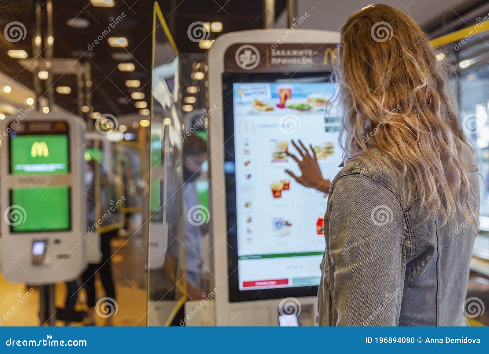 Young Blonde Woman in McDonald`s Makes an Order Online. Moscow, Russia ... Young Blonde Woman in McDonald`s Makes an Order Online. Moscow, Russia ...