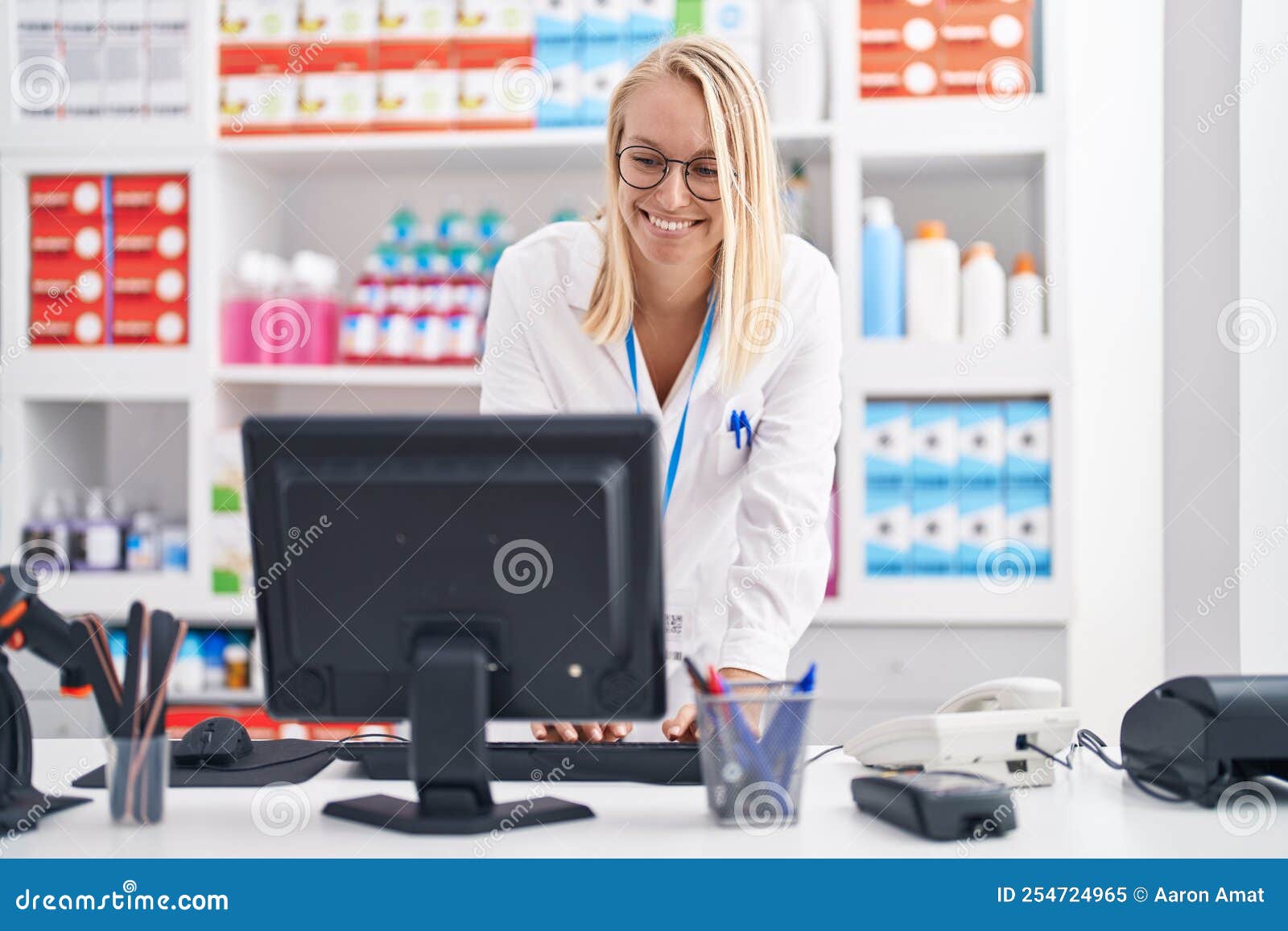 Young Blonde Woman Pharmacist Using Computer Working at Pharmacy Stock ...