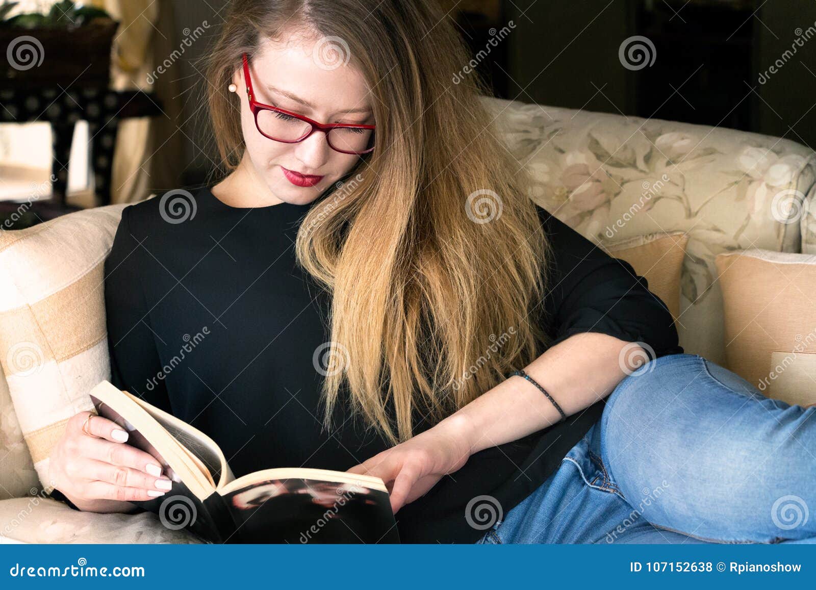 Portrait Of A Blonde Young Woman Reading A Book Wearing Eyeglass Stock