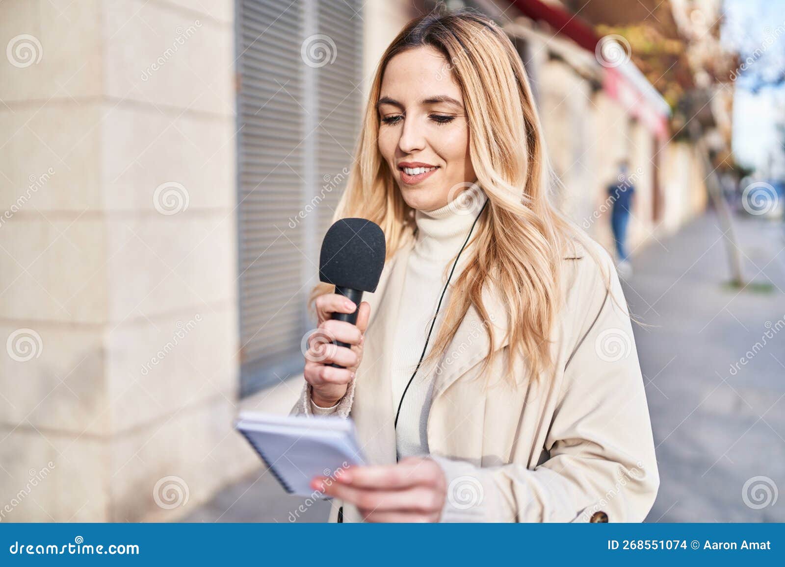Young Blonde Woman Reporter Working Using Microphone Reading Notebook ...