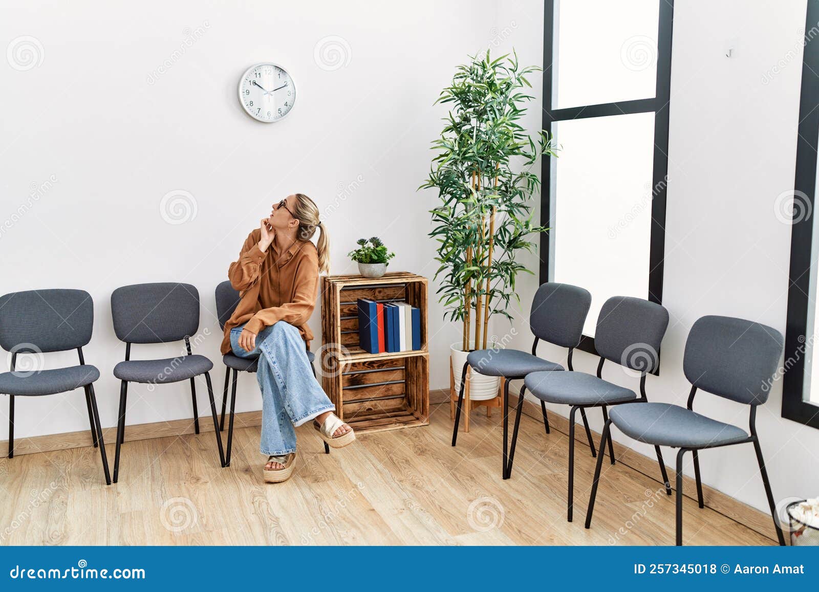 Young Blonde Woman with Serious Expression at Waiting Room Stock Photo ...