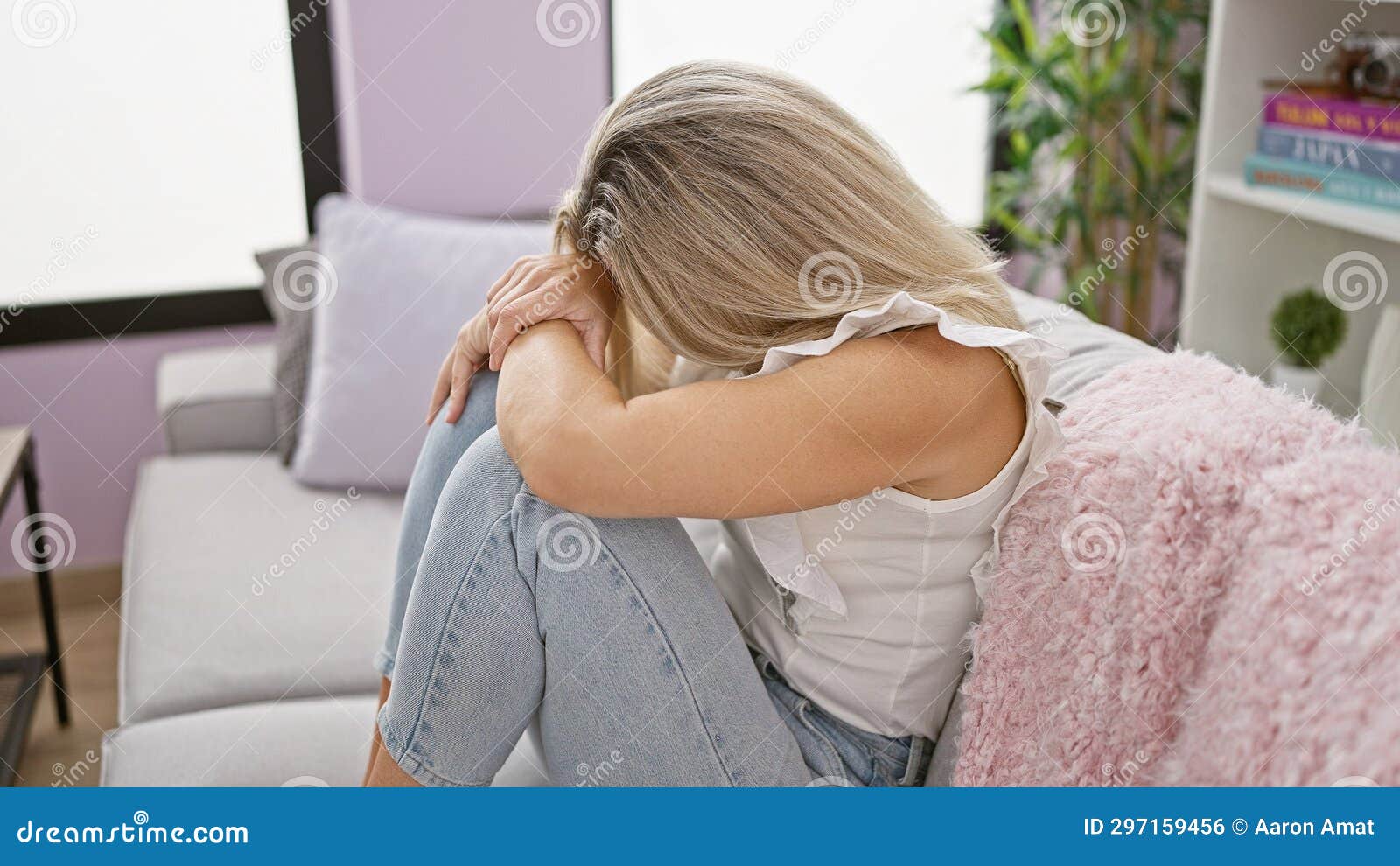 Young Blonde Woman Sitting on Sofa with Sad Expression at Home Stock ...