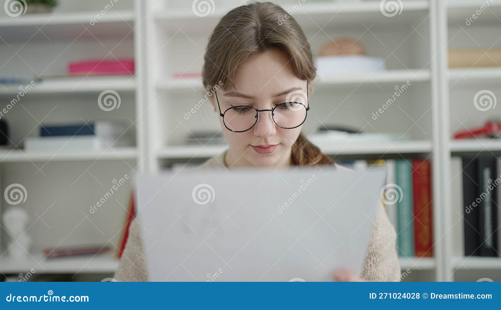 Young Blonde Woman Student Reading Document at Library University Stock ...
