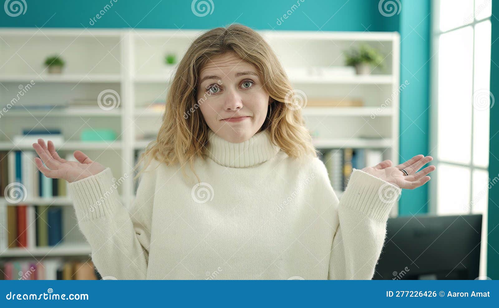 Young Blonde Woman Student Standing with Confused Expression at Library ...