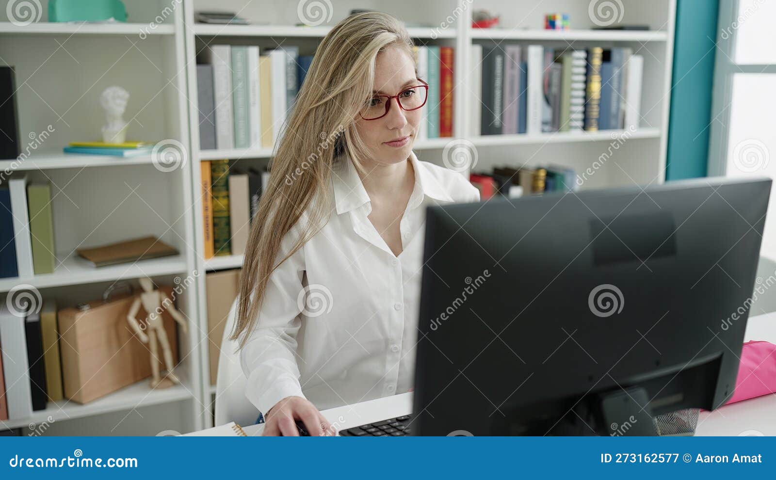 Young Blonde Woman Student Using Computer Sitting on Table at Library ...