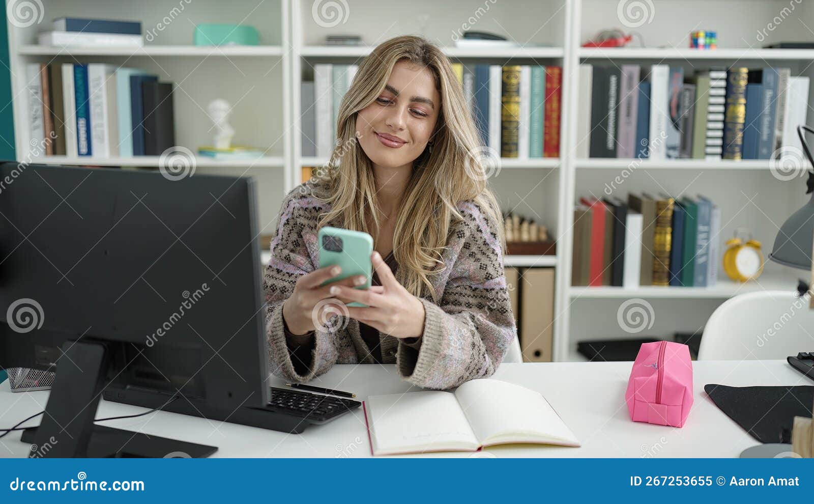 Young Blonde Woman Student Using Computer and Smartphone Studying at ...