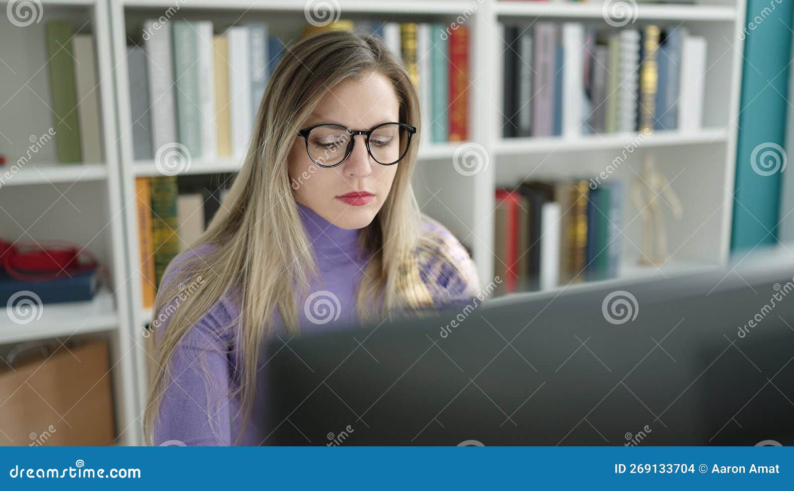 Young Blonde Woman Student Using Computer Studying at Library ...
