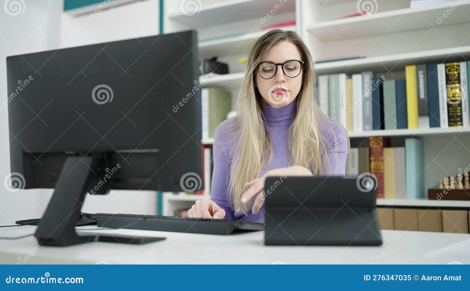 Young Blonde Woman Student Using Computer and Touchpad Studying at ...