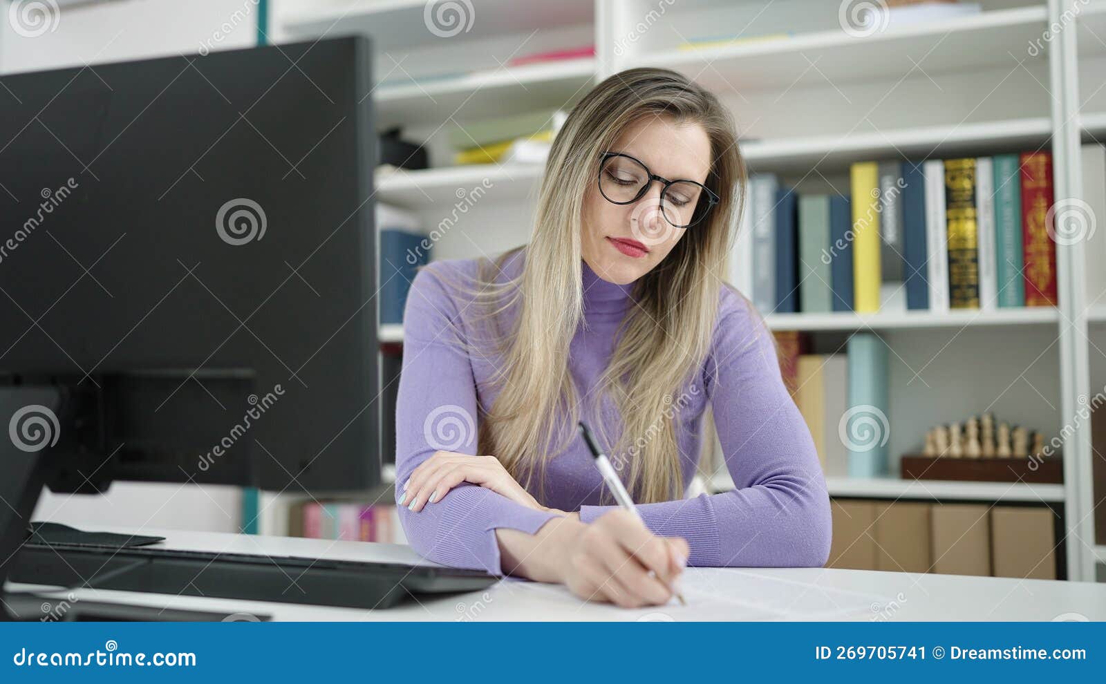 Young Blonde Woman Student Using Computer Writing on Document at ...