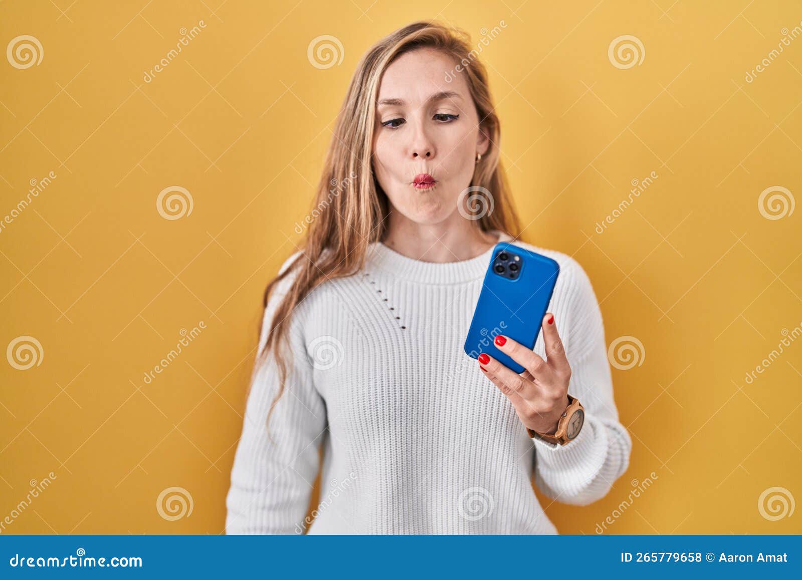 Young Blonde Woman Using Smartphone Typing Message Making Fish Face ...