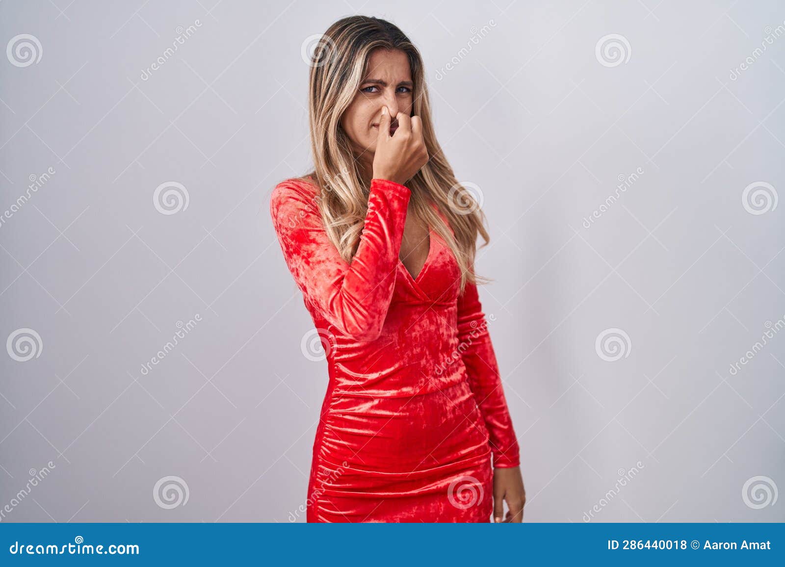 Young Blonde Woman Wearing Party Dress Smelling Something Stinky And