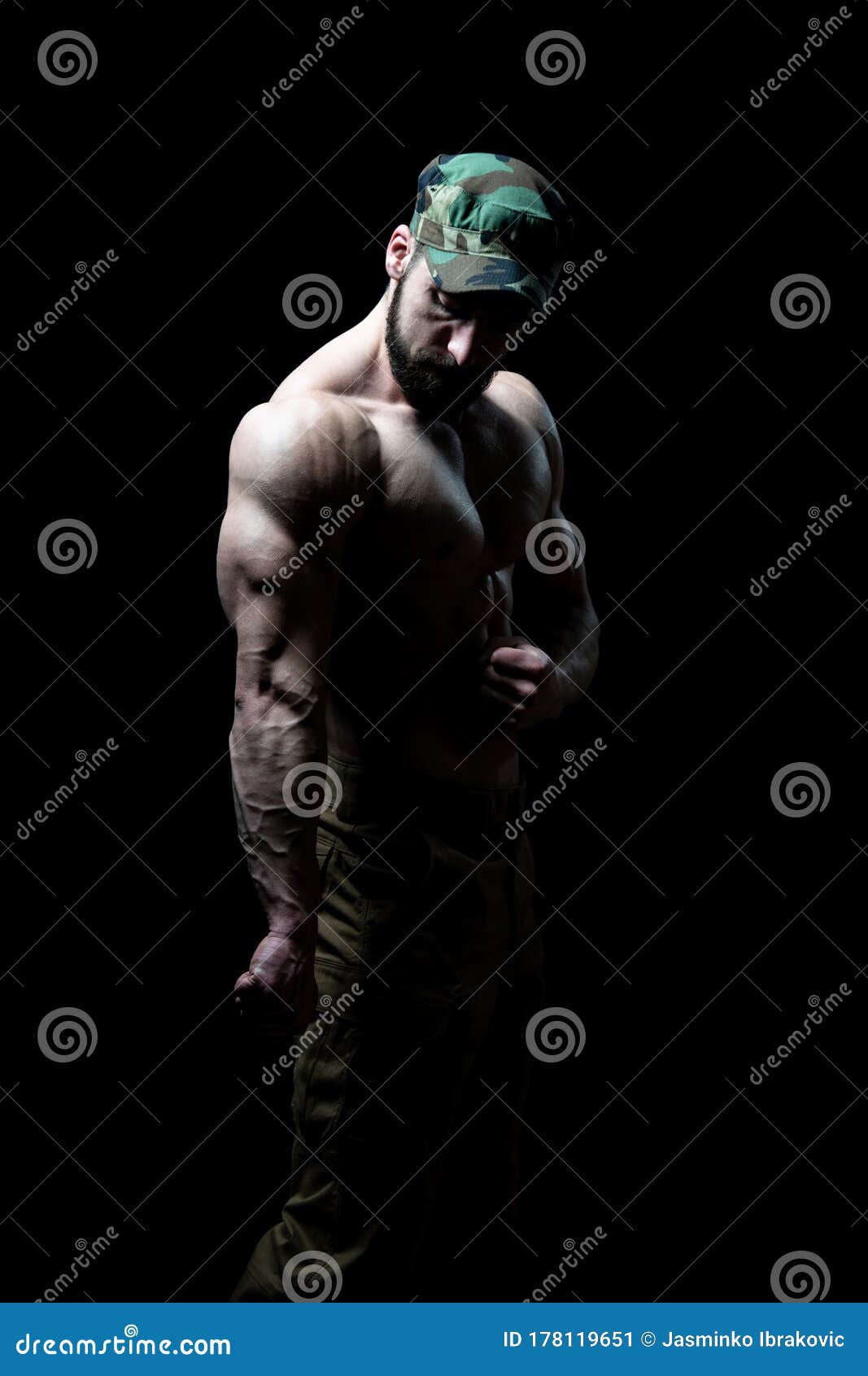 Man Standing and Flexing Muscles on Black Background Stock Image ...