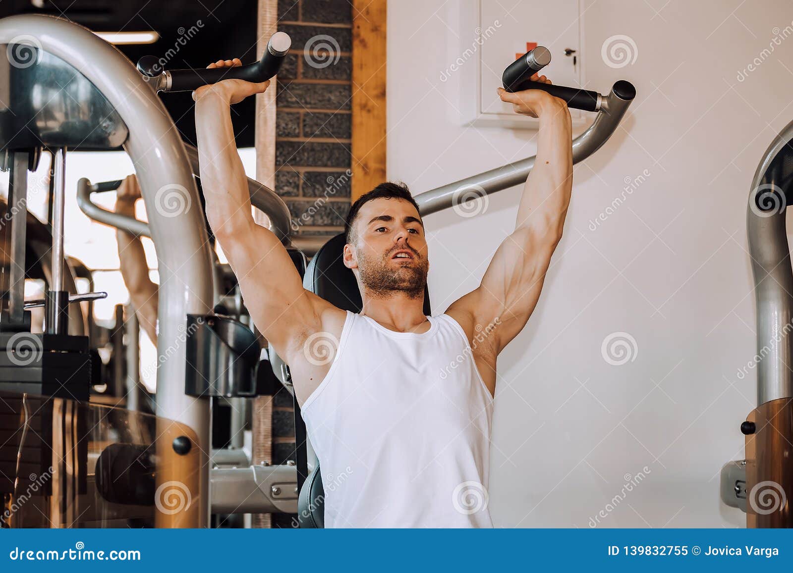 Young Bodybuilder Training in Gym on Machine Stock Image - Image of ...