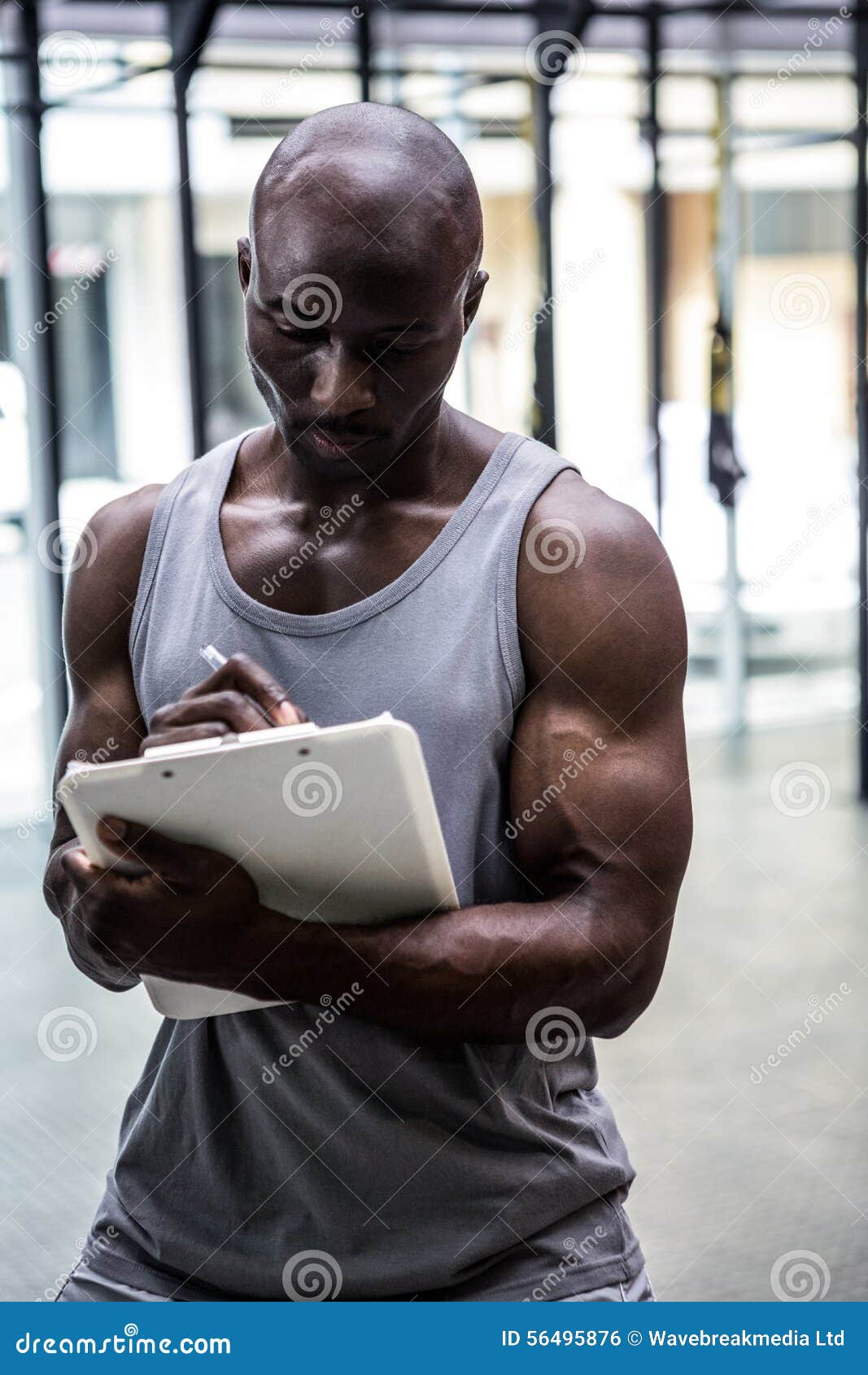 Young Bodybuilder Writing on a Clipboard Stock Photo - Image of ...
