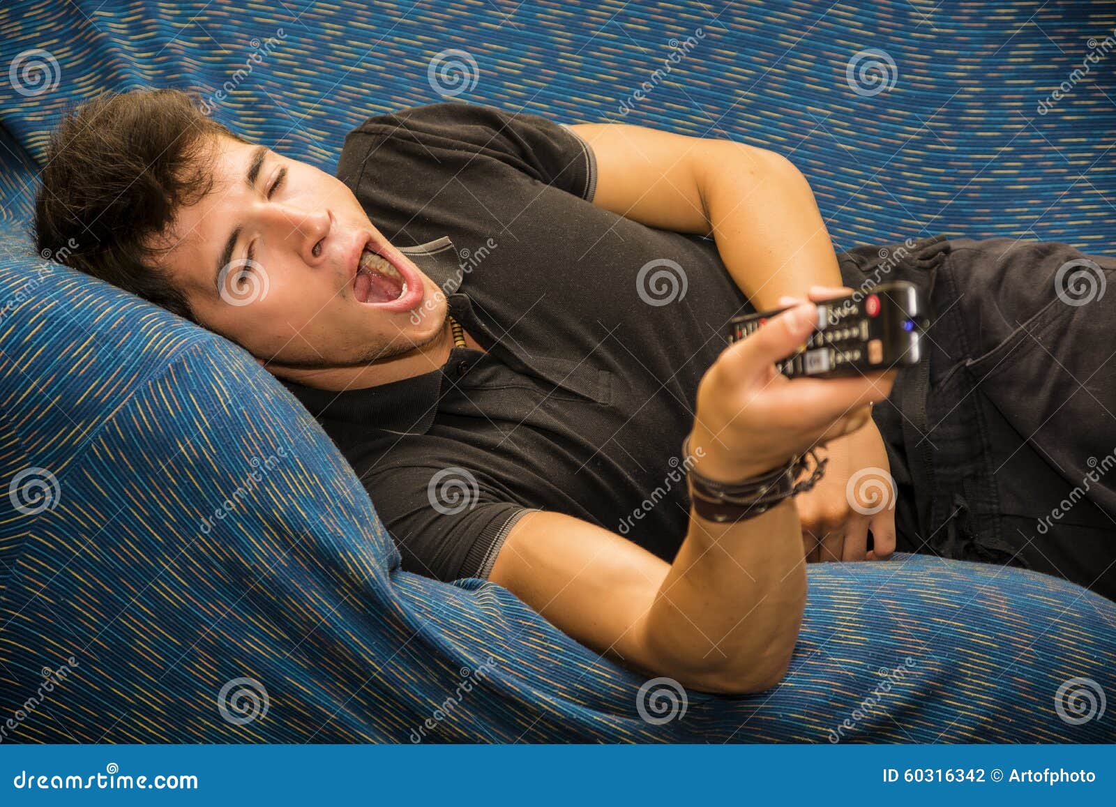 Young Bored Man Sitting on Sofa Watching Stock Photo - Image of inside ...