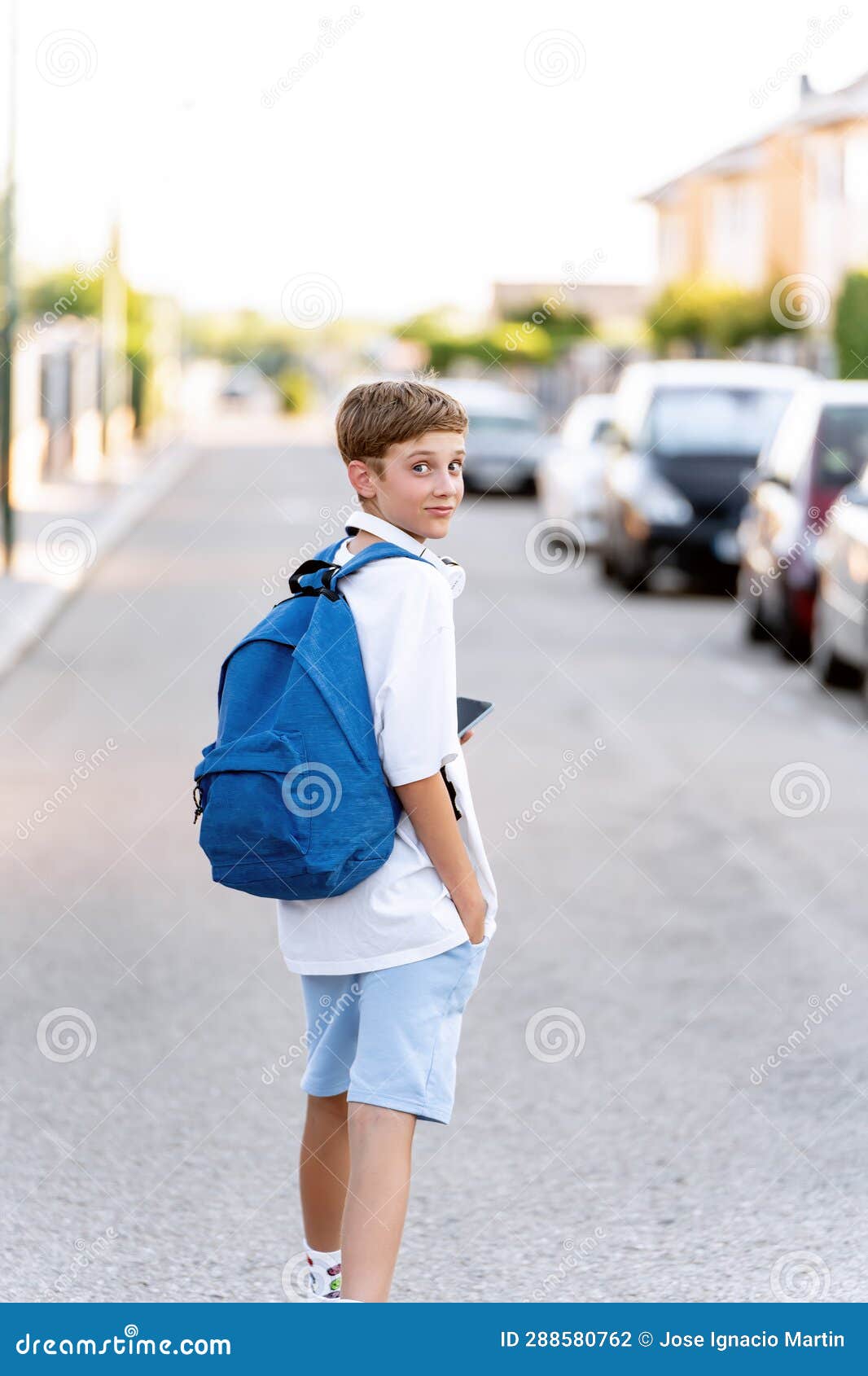 Young Boy with Backpack Looking at Camera while Walking on the Street ...