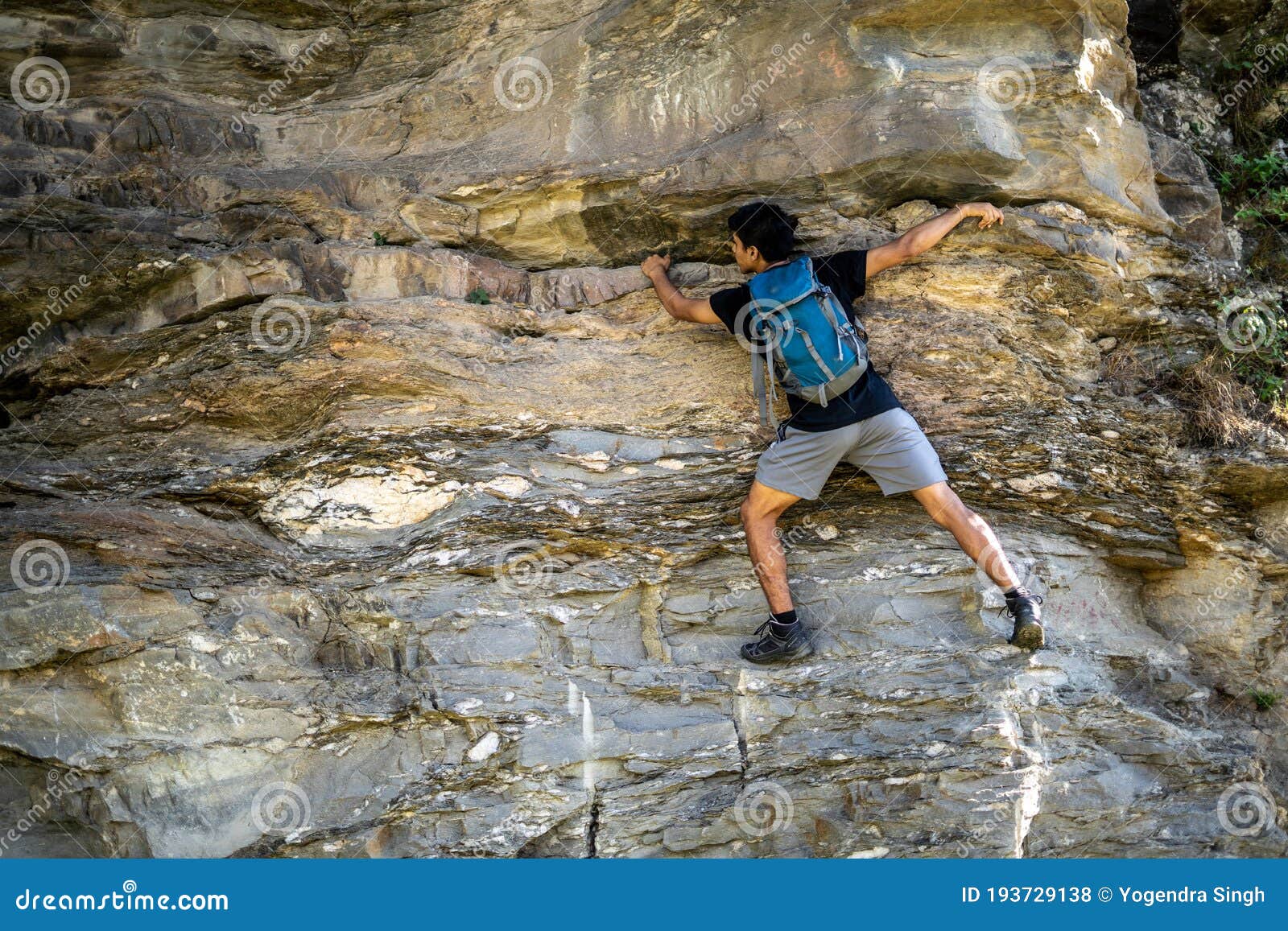 Young Boy Climbing the Rocks Wearing a Backpack Stock Photo - Image of ...