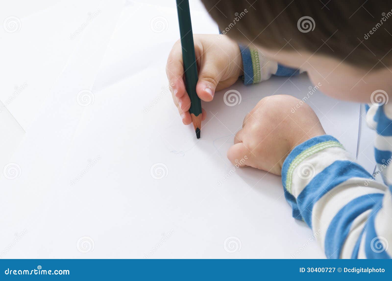 Young Boy Concentrates while Drawing with a Green Pencil Stock Image ...