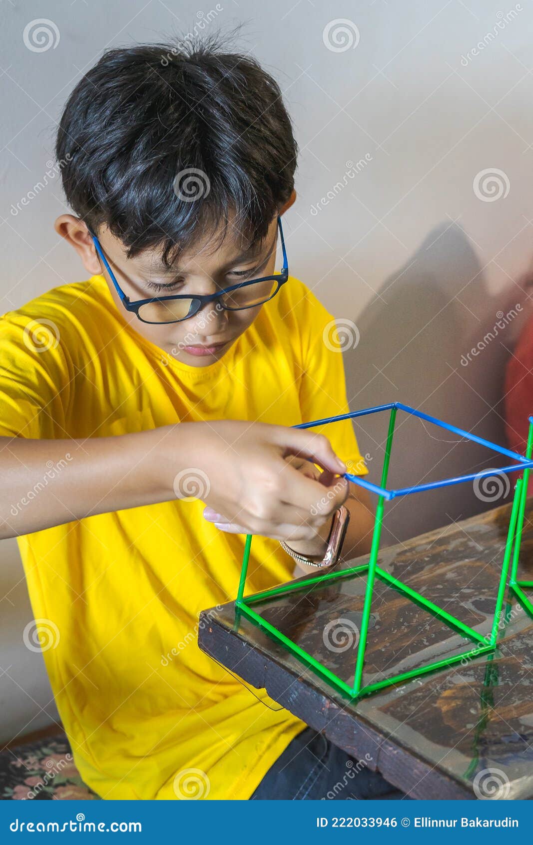 A Young Boy is Constructing Colorful Plastic Sticks with Glue Gun. Fun ...