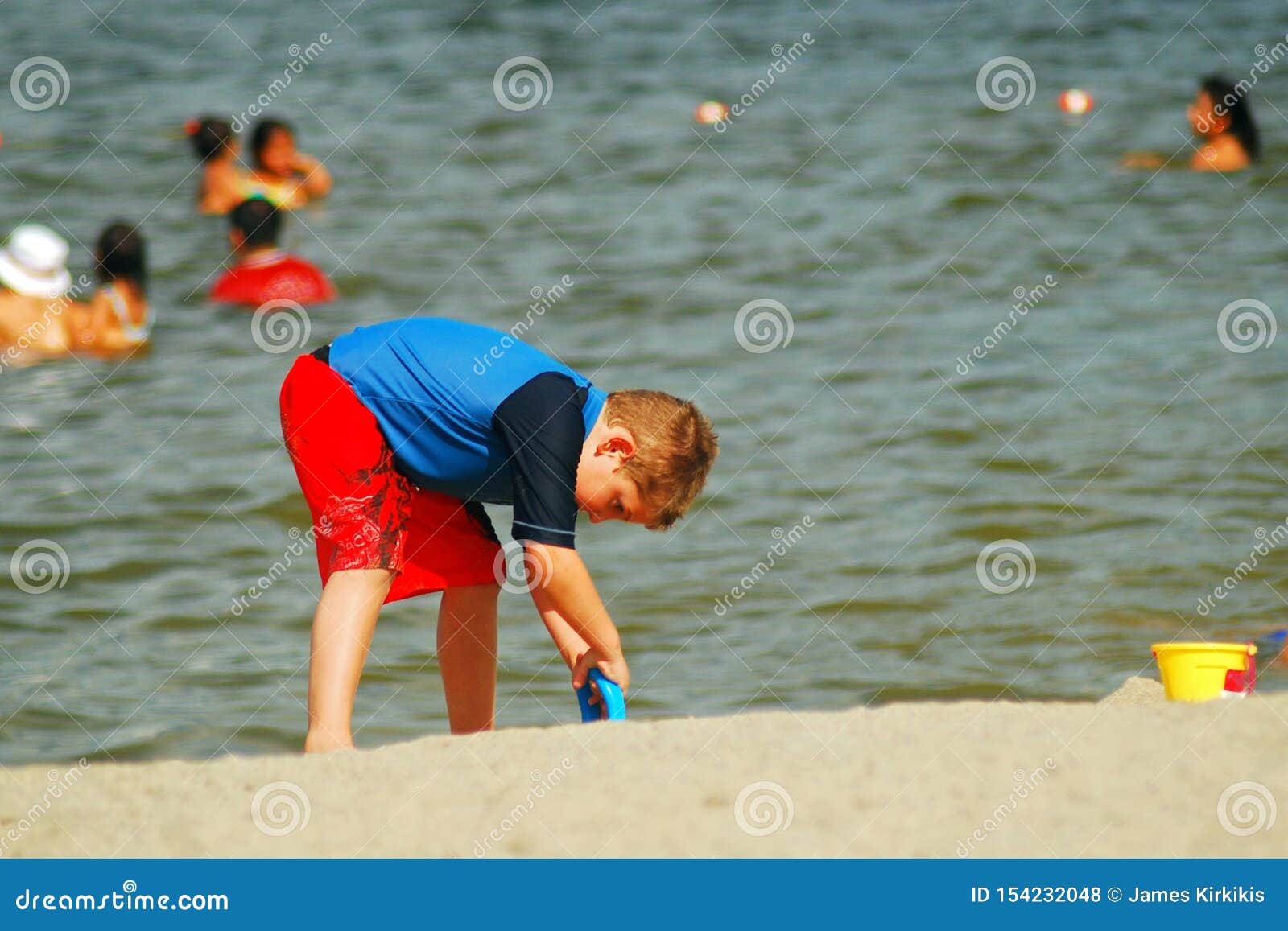A Young Boy Digs at the Beach Stock Photo - Image of coastal ...