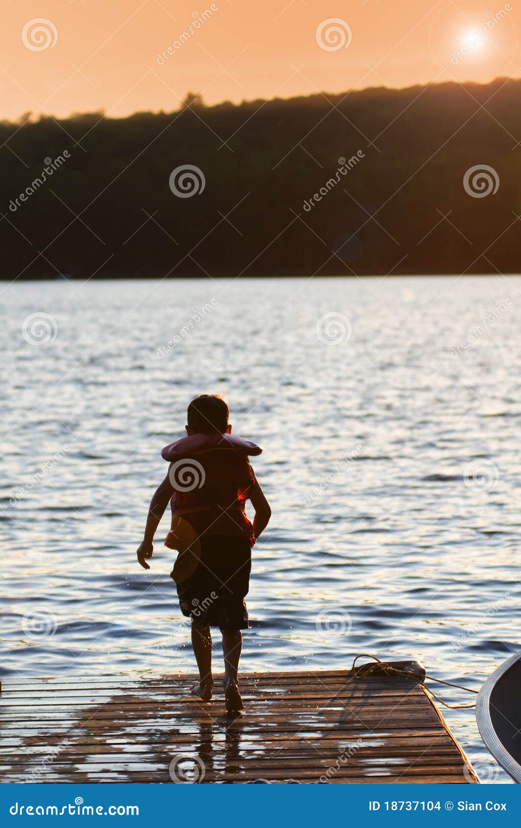 Young Boy on a Dock at Sunset Stock Photo - Image of evening, swim ...