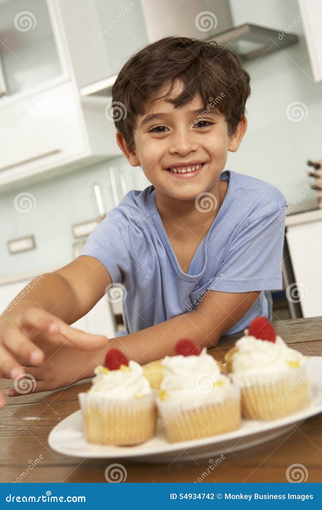 Young Boy Eating Cakes in Kitchen Stock Photo - Image of happy, inside ...