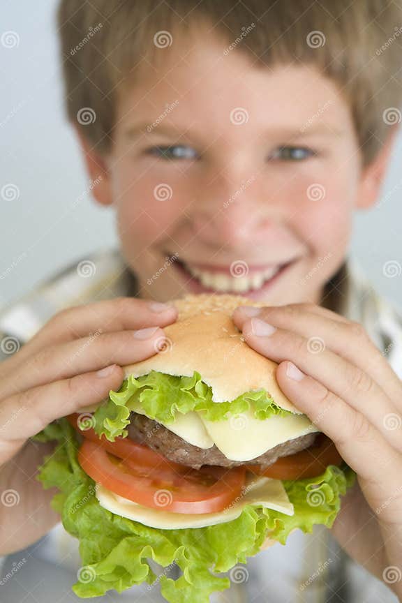 Young Boy Eating Cheeseburger Smiling Stock Photo - Image of head ...