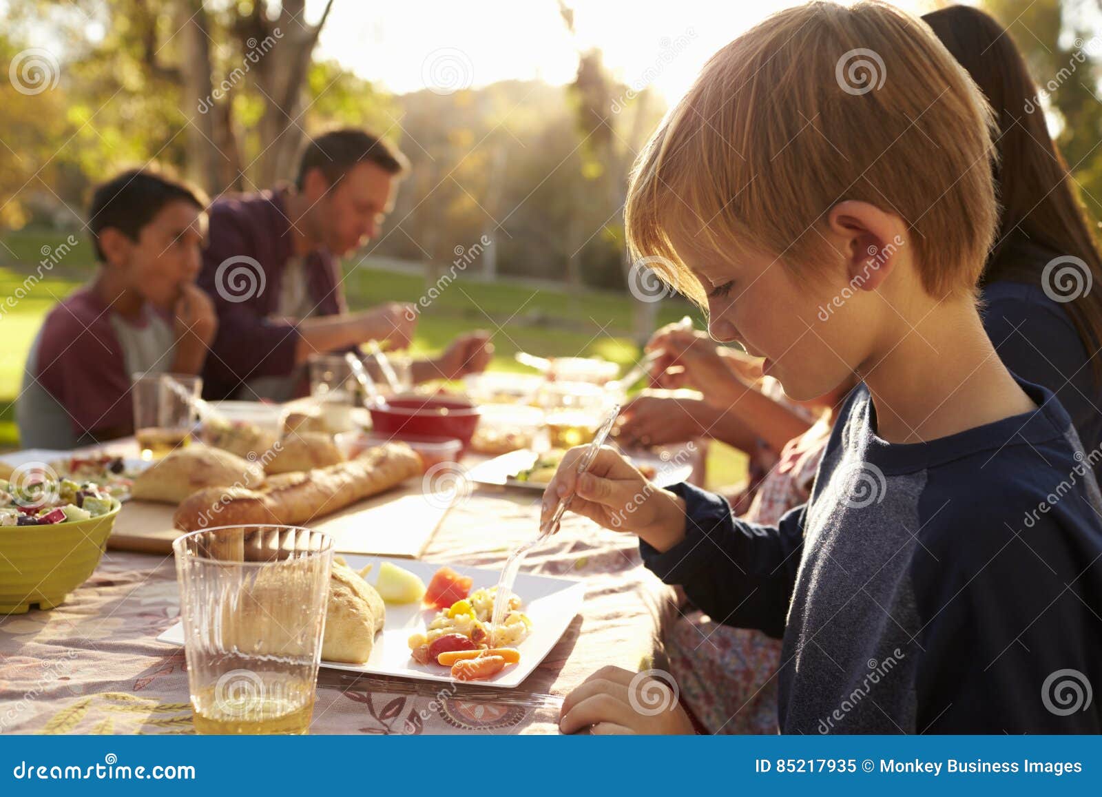 Young Boy Eating at a Picnic Table in a Park Stock Image - Image of ...