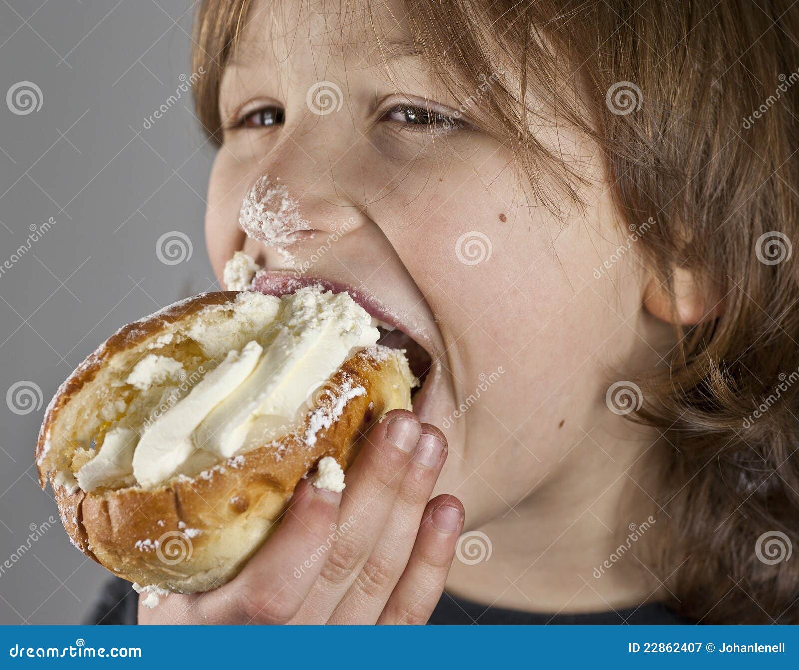Young Boy Enjoying a Cream Bun with Almond Paste Stock Image - Image of ...