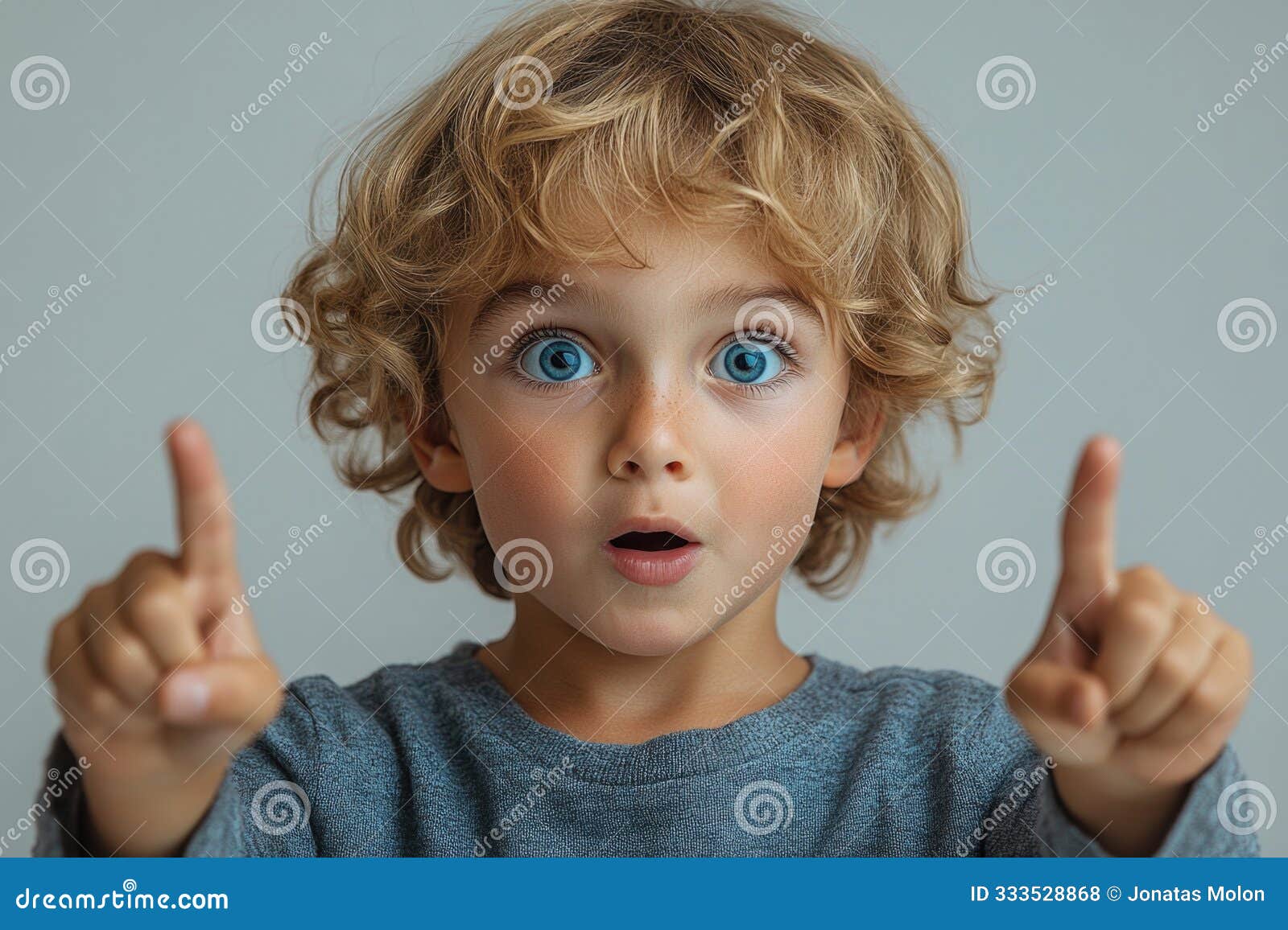 Young Boy Excitedly Pointing at Empty Space with Wonder on His Face Aga ...