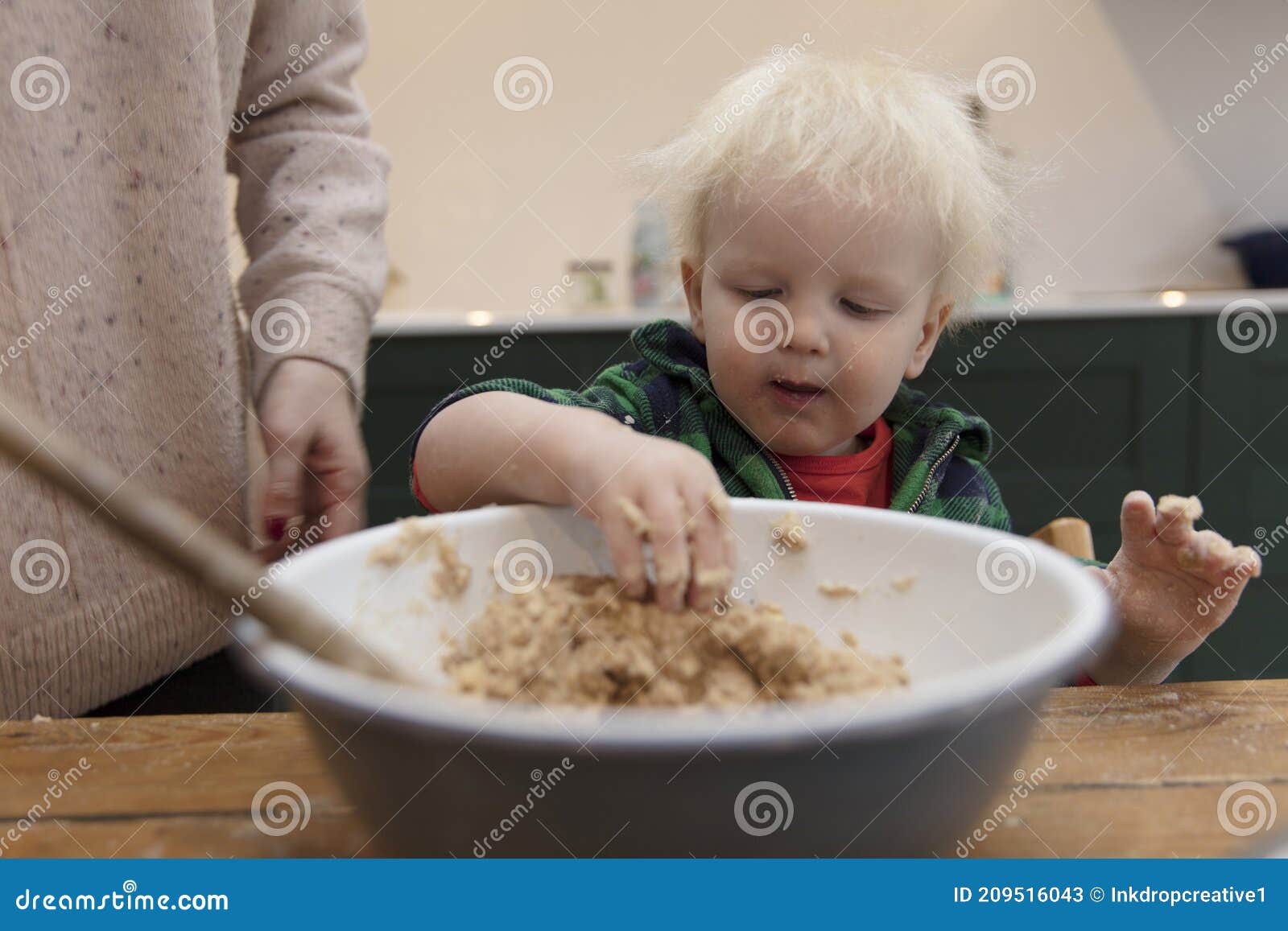 A Young Boy Gets His Hands into the Cake Mixture Whilst Helping To Bake ...