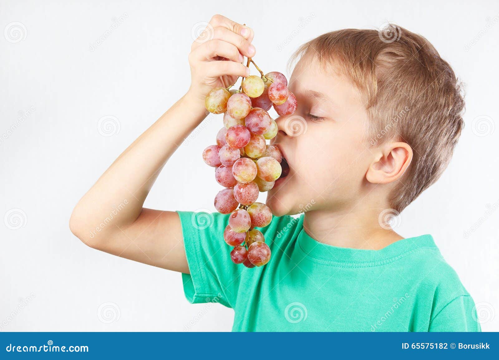 Young Boy in a Green Shirt Eating Grape Stock Photo - Image of diet ...