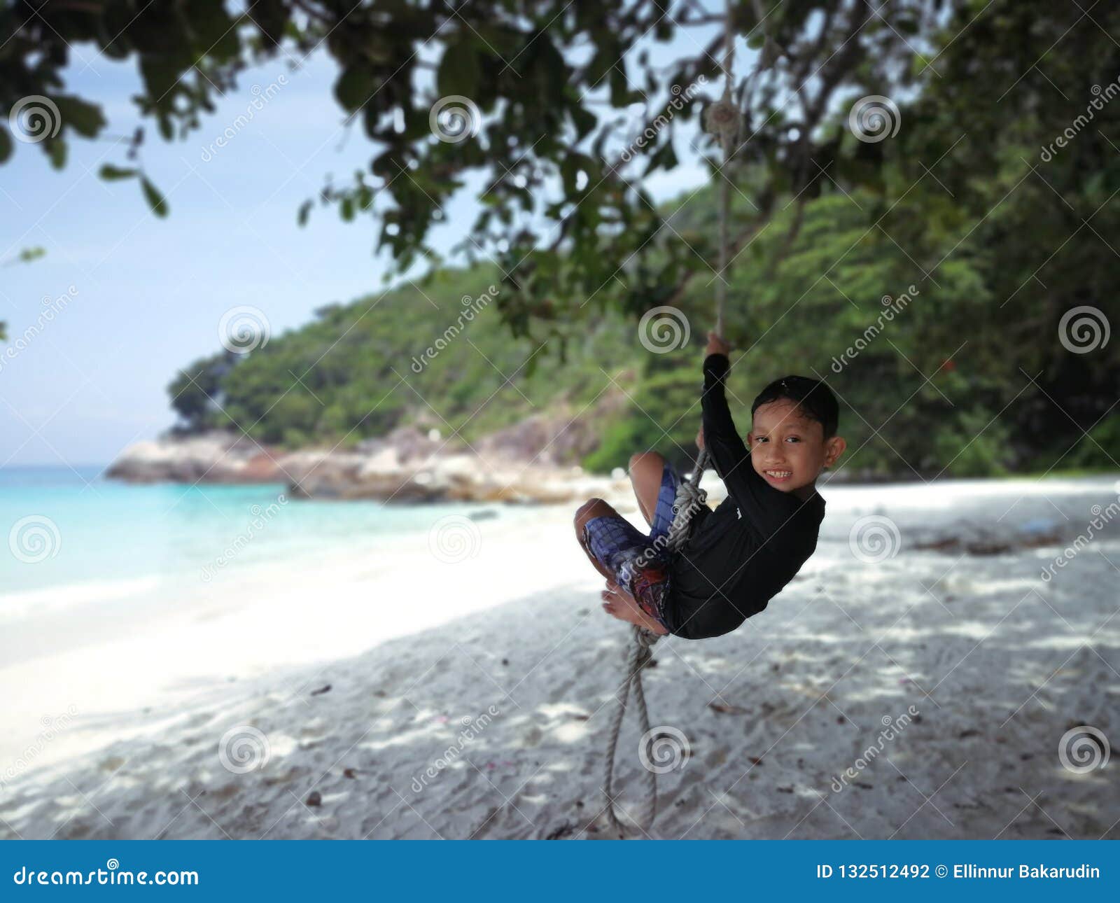 A Young Boy is Hanging at the Rope by the Beach. Stock Photo - Image of ...